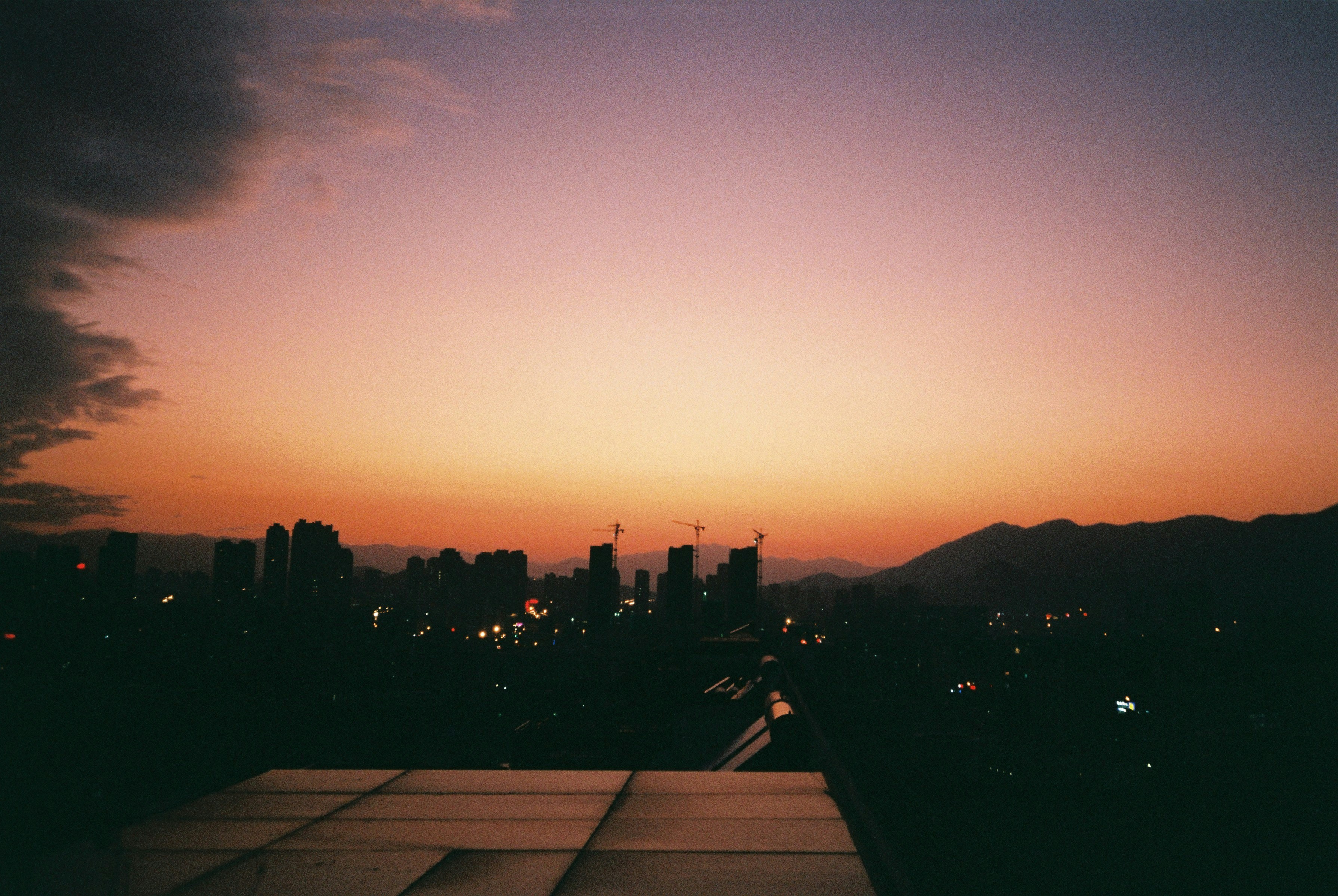 A view of a city at sunset from a rooftop photo – Free Sunset Image on ...
