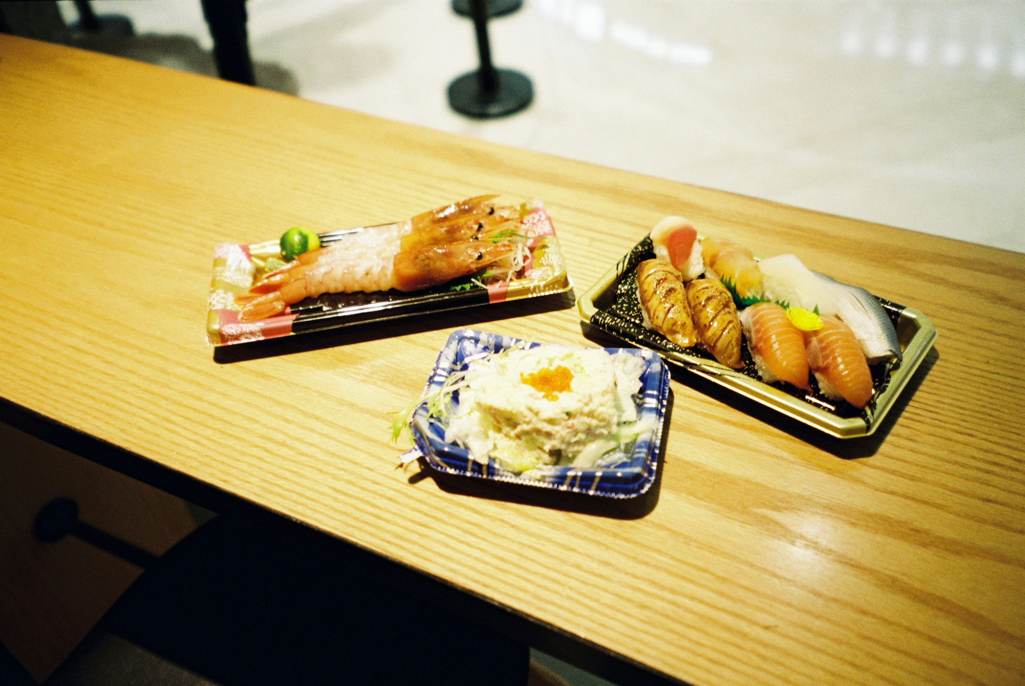 Bar-Top Sushi Trio Under Warm Indoor Light