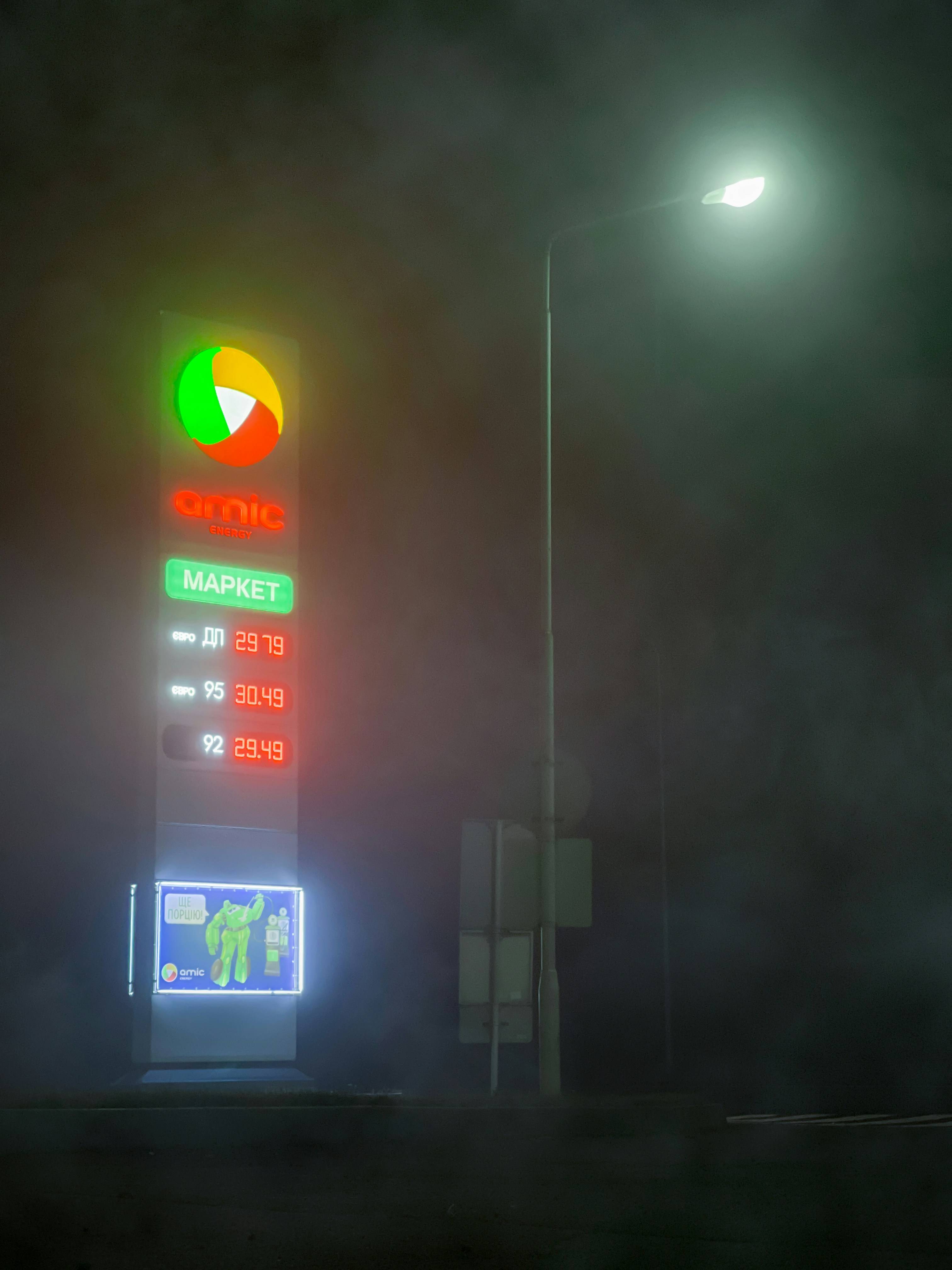 A gas station sign lit up at night photo – Free Ukraine Image on Unsplash