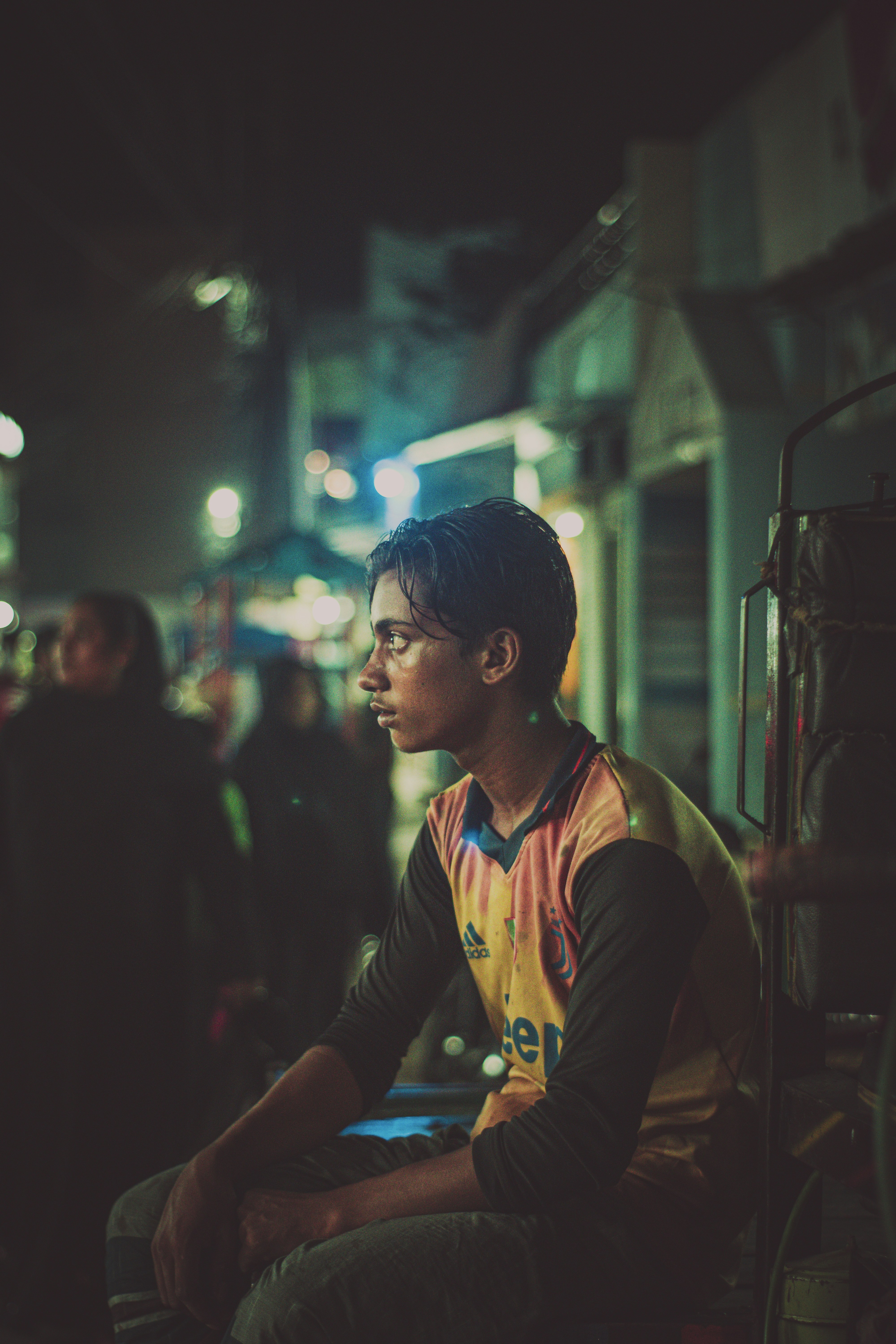 Neon Quiet: Portrait of a Young Man on a Night Market Street