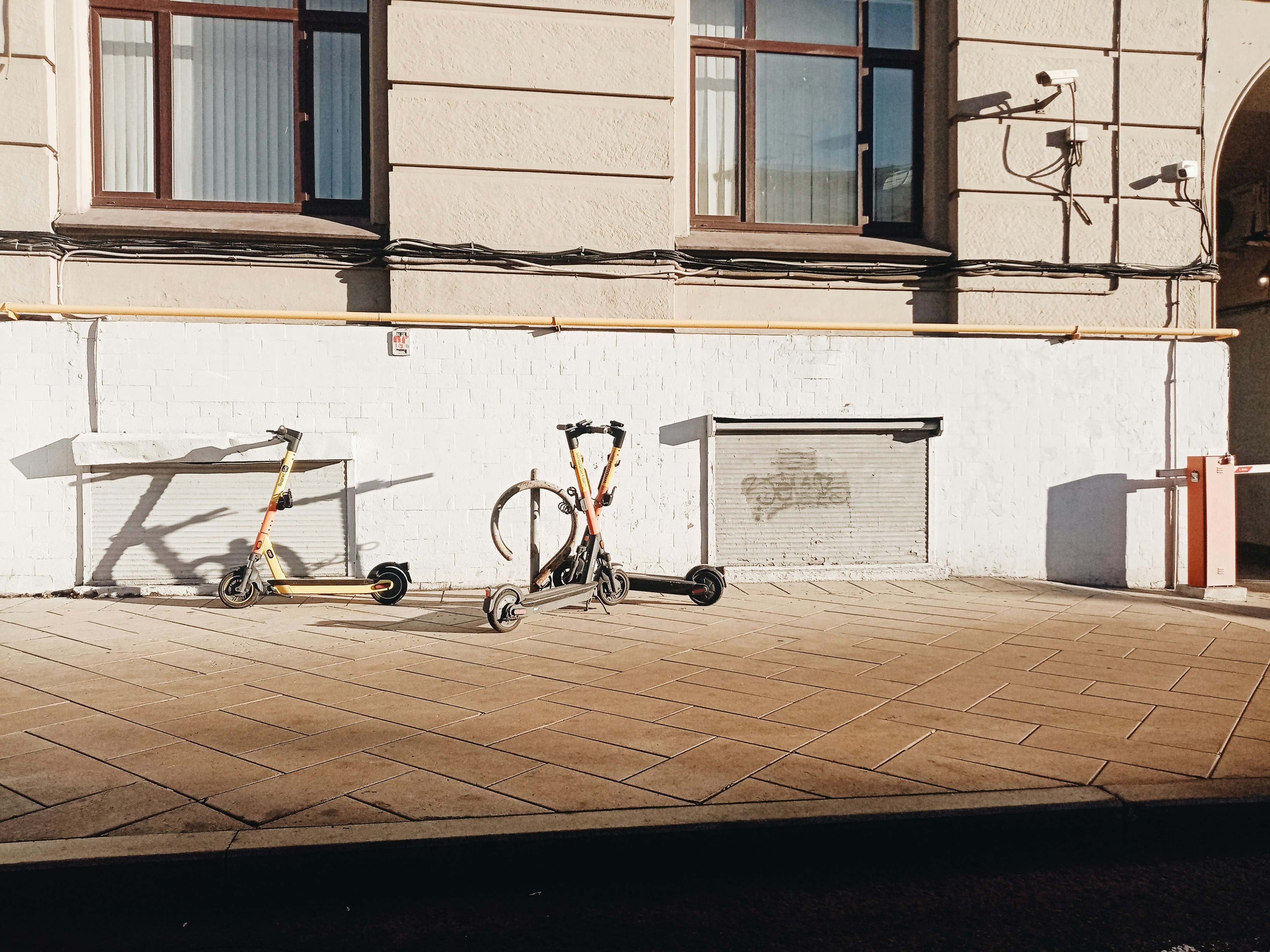 Sunlit Row: Scooters Rest Beside a Bare City Facade
