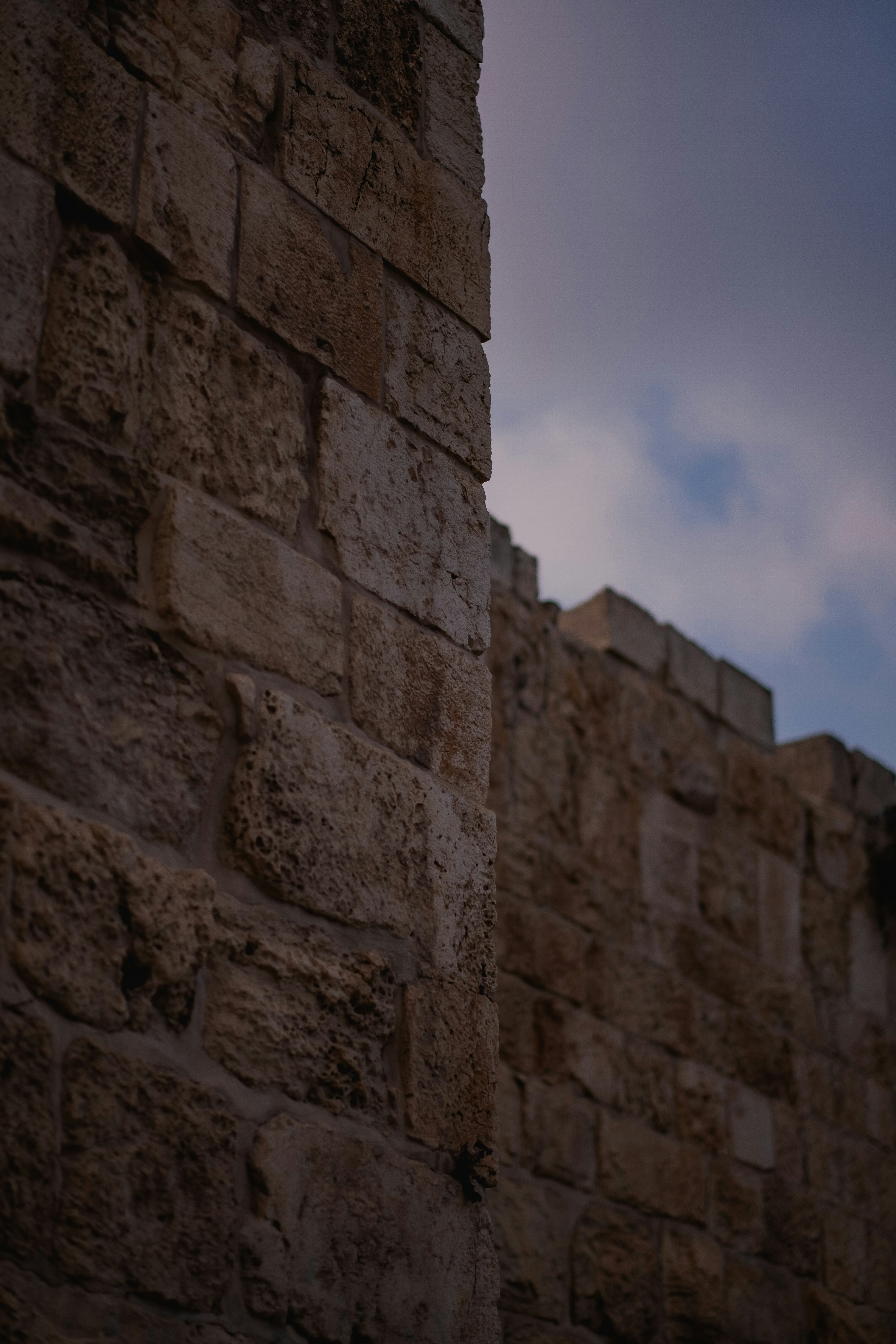 The walls of the Old City of Jerusalem, Israel. | a close up of a brick wall with a sky in the background