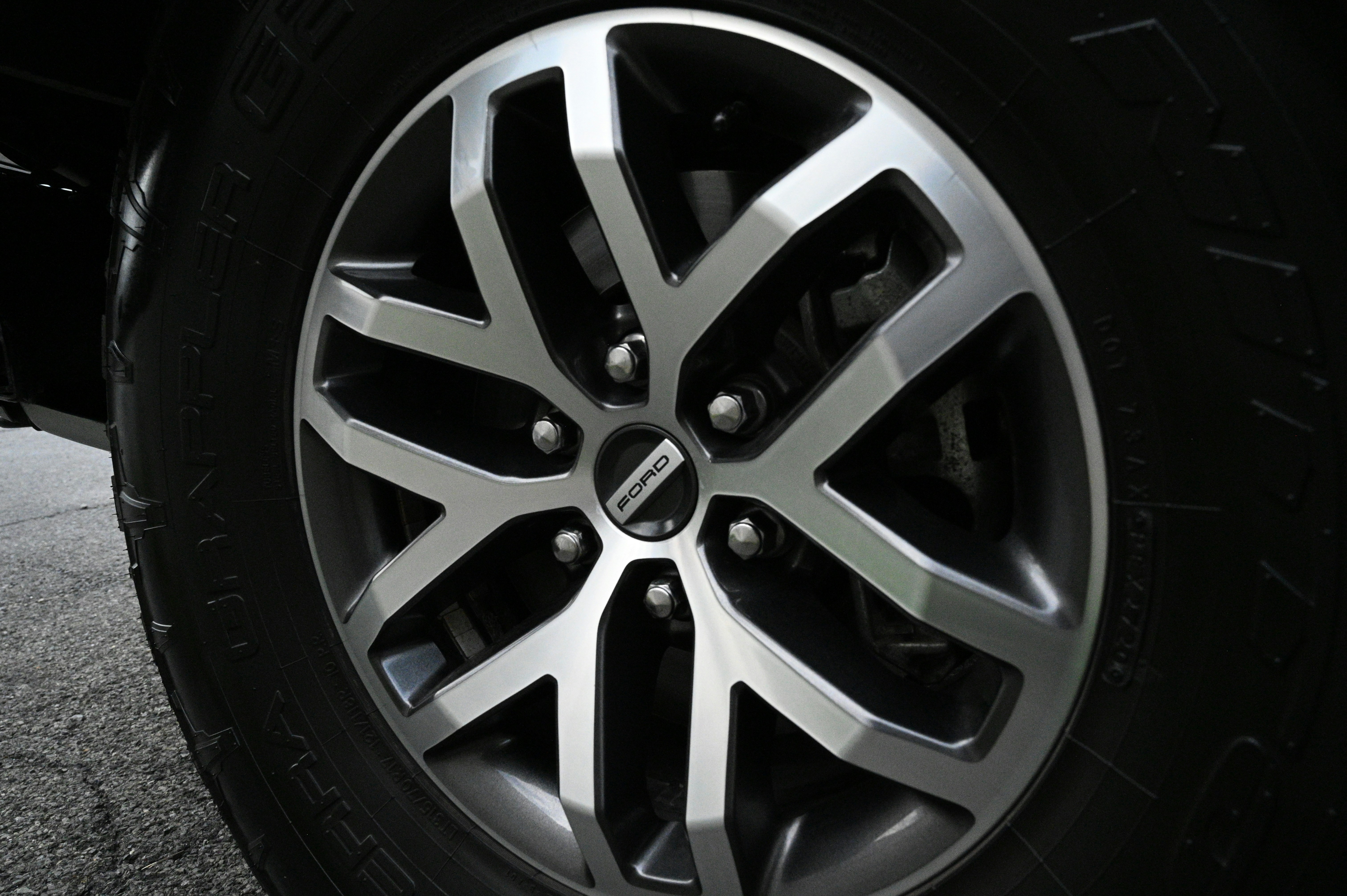 Chrome-Spoked Wheel in Sharp Focus Under Street Light