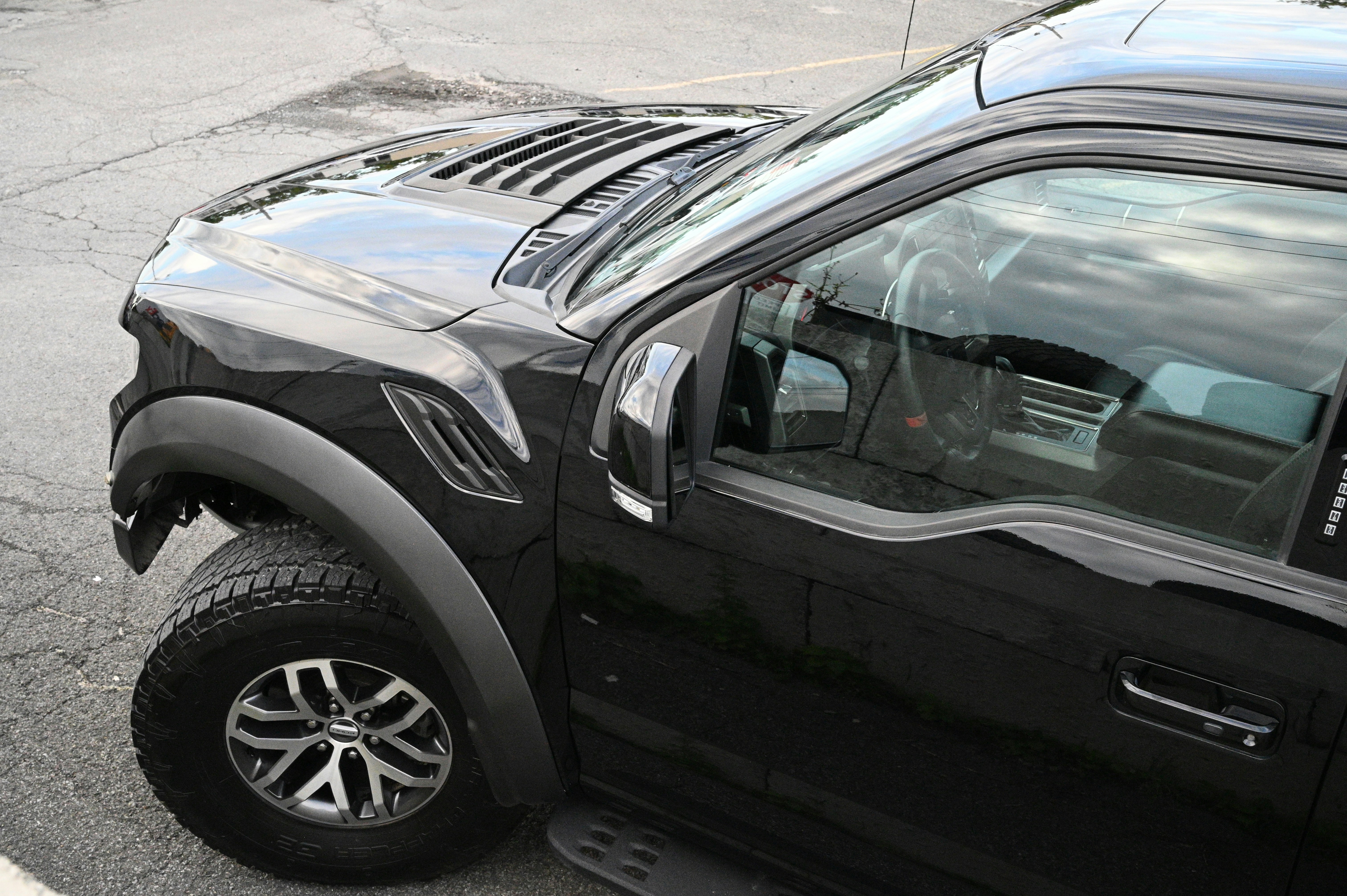 A black truck parked on the side of the road photo – Free Ford raptor ...