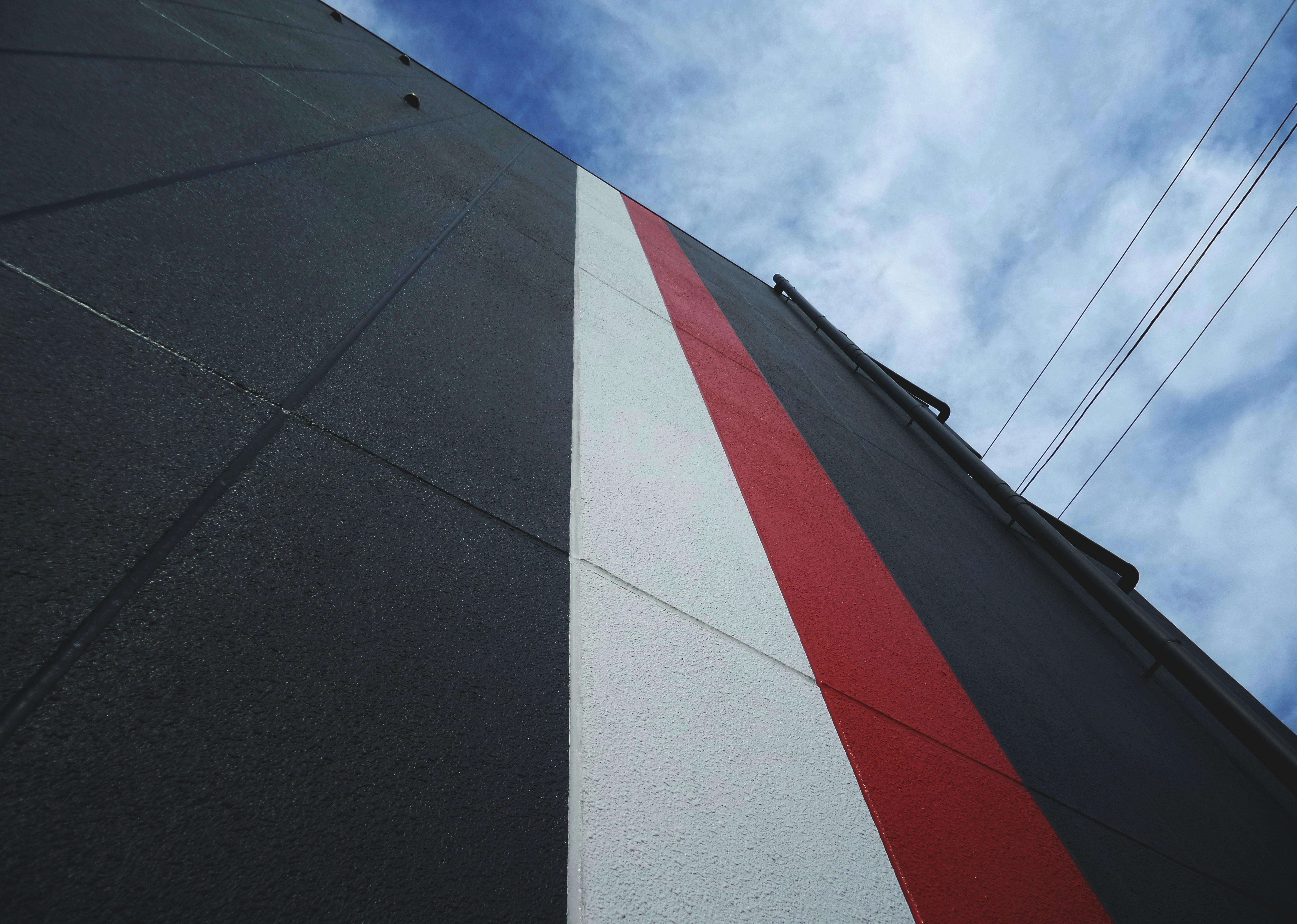 a tall building with a red, white and black stripe on it