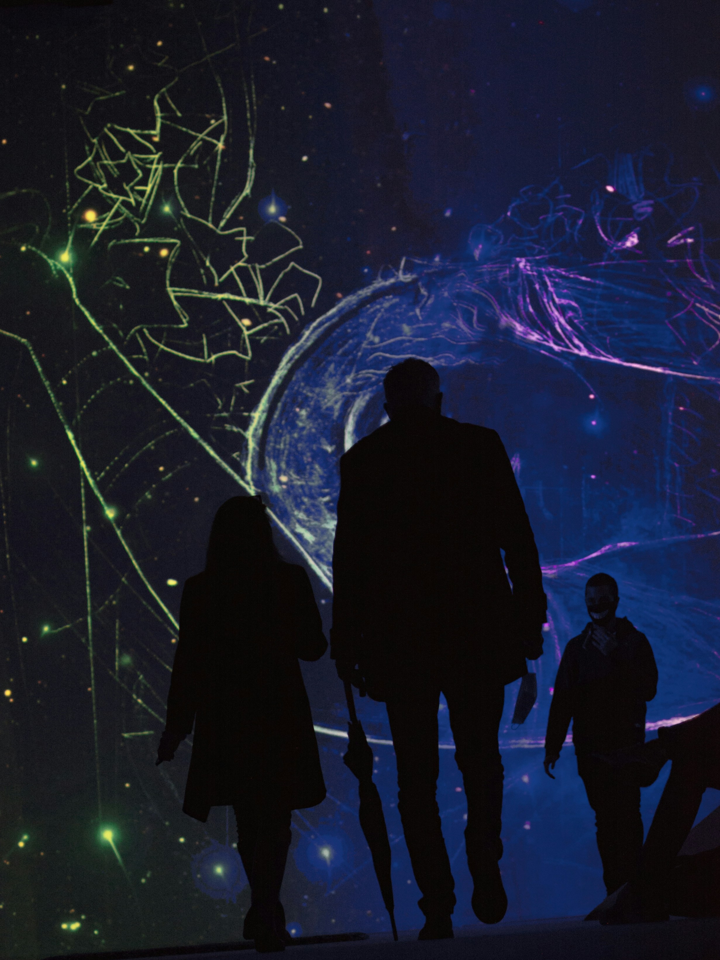 Nebula Steps: Silhouettes Against a Neon Cosmos Projection