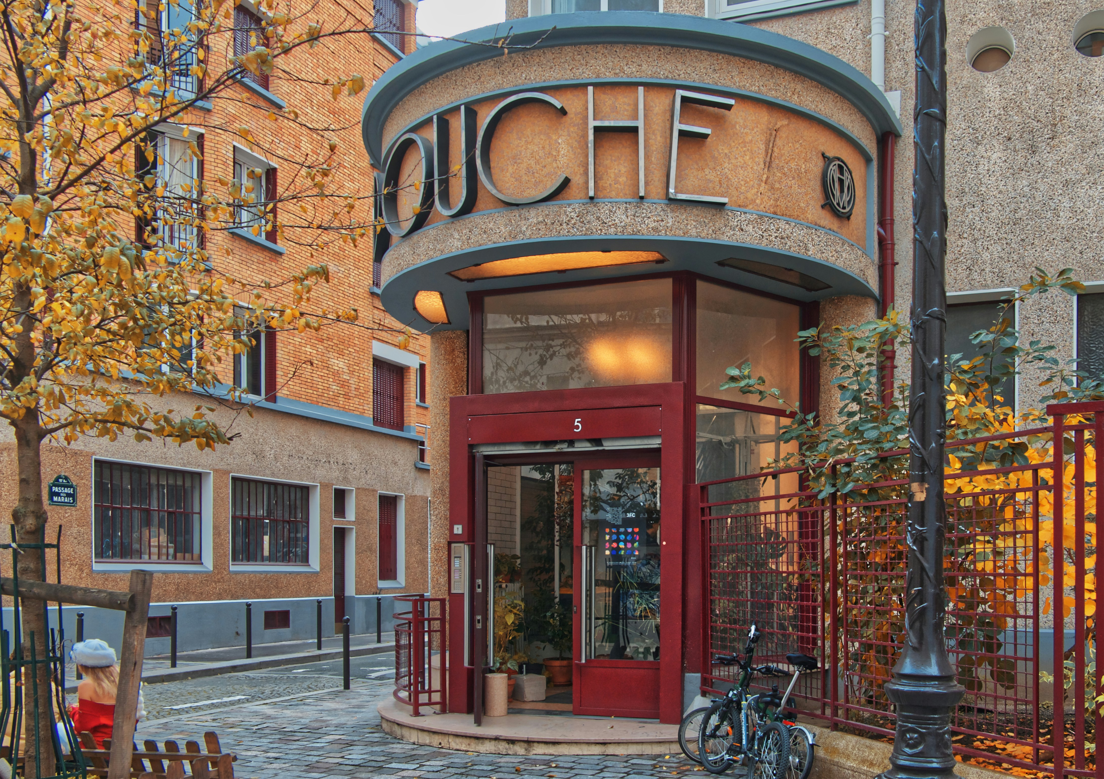 Red Doorway Under the Circular Sign on an Autumn Street