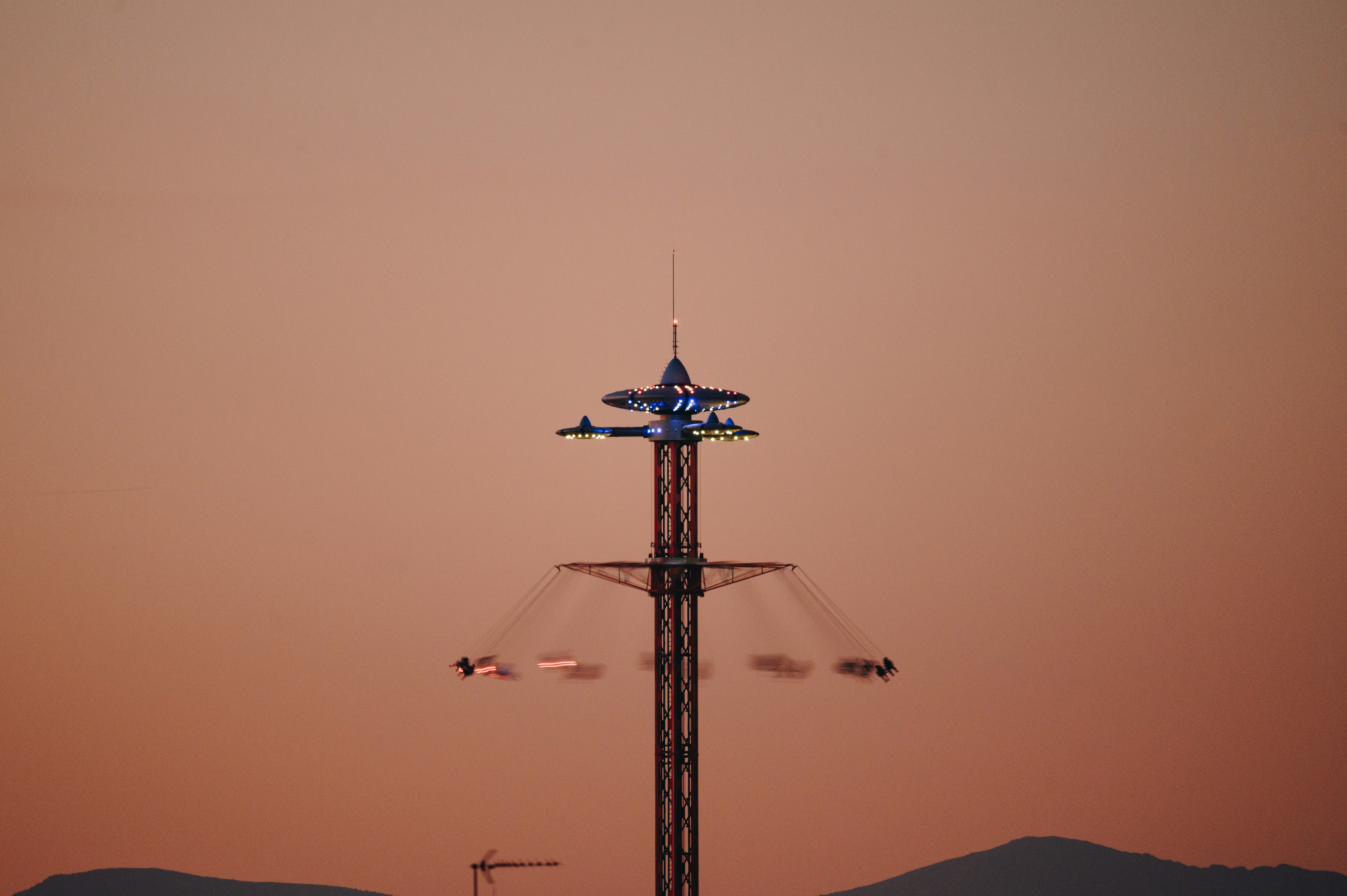 Cobalt Crown at Dusk: a lattice tower with blue-lit rotating arms