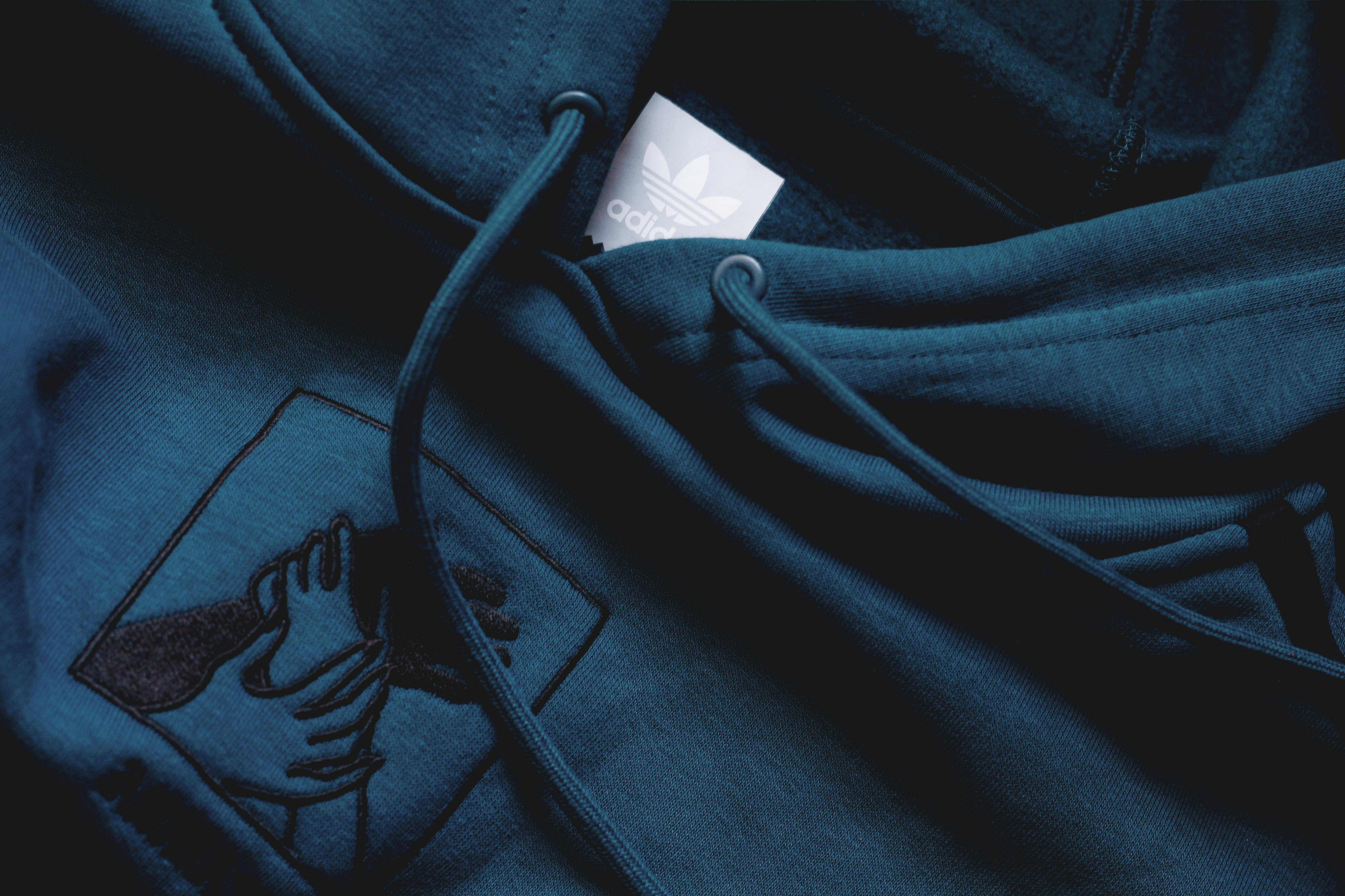 A close up of a hoodie with a tag on it photo – Free Blue Image on Unsplash