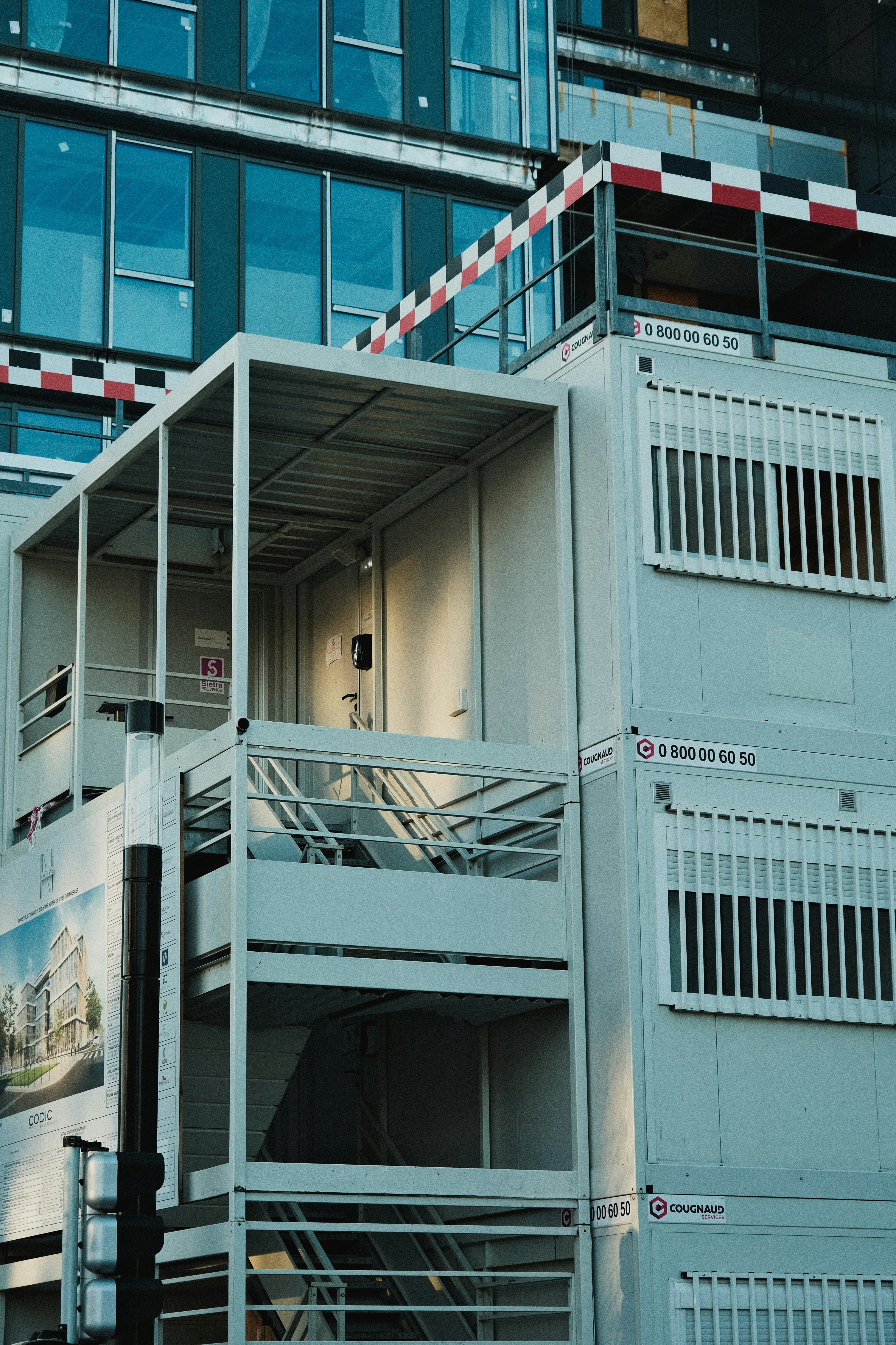 a tall white building with a metal balcony
