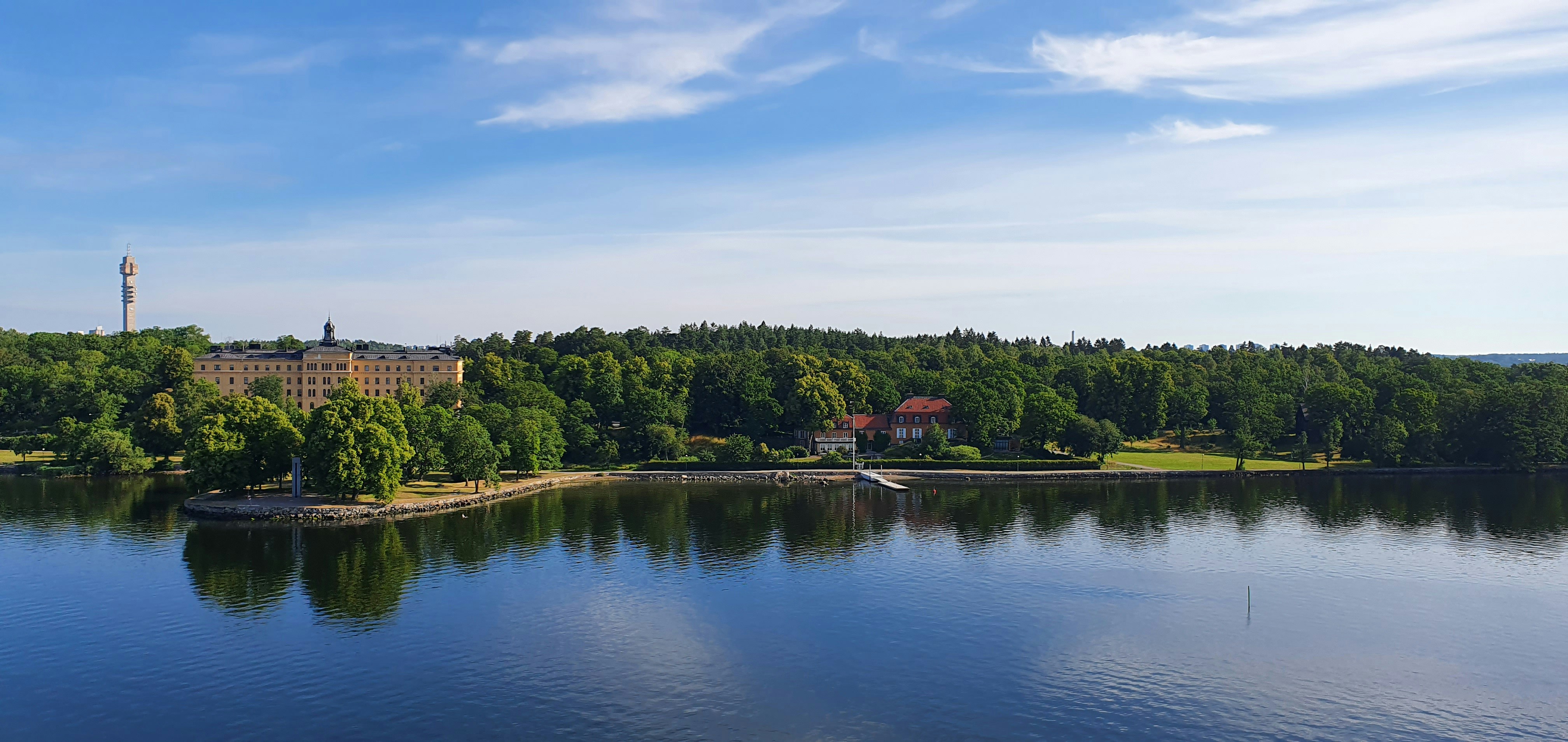A lake surrounded by trees and a large building photo – Free Stockholm ...
