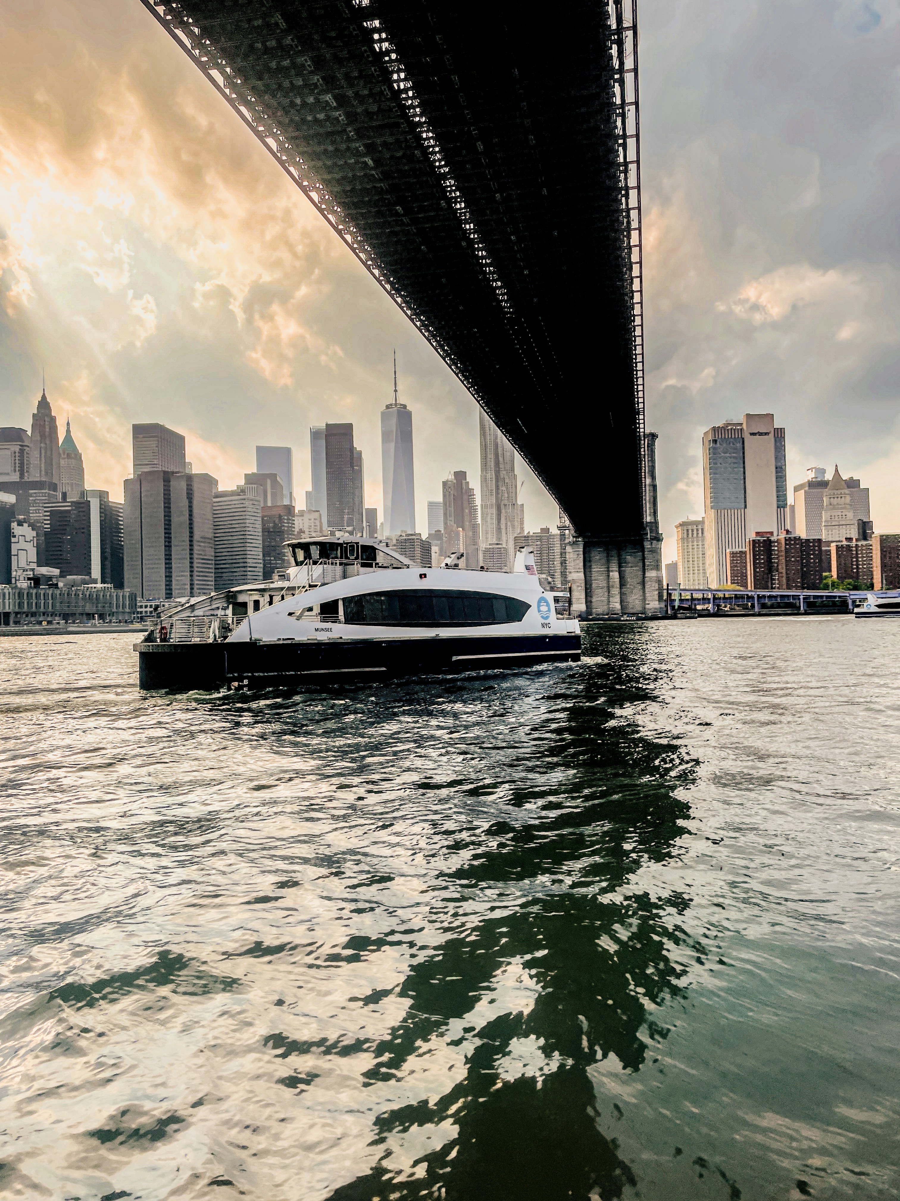 A boat floating under a bridge in the water photo – Free Nyc Image on ...