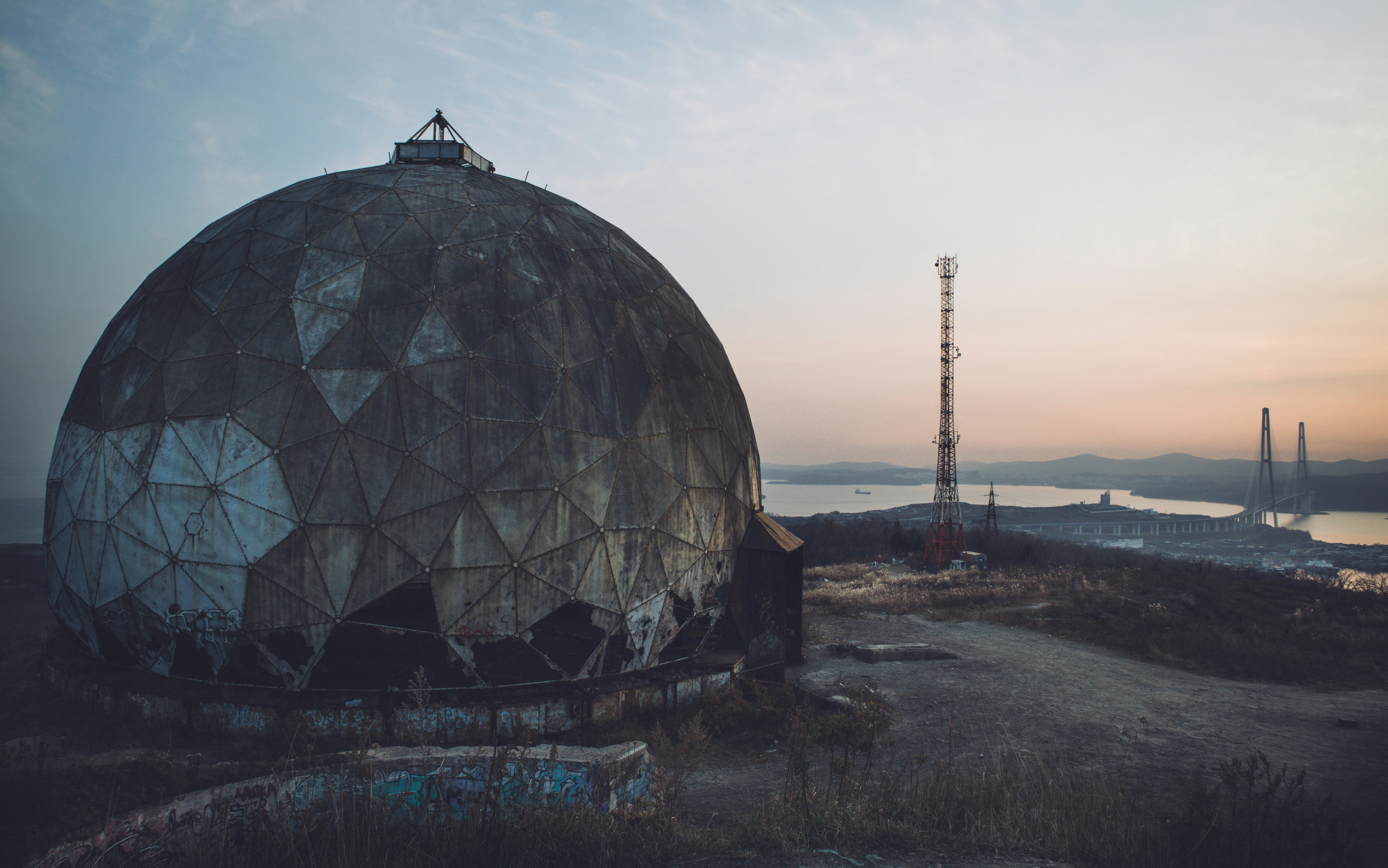 A large metal dome sitting on top of a dirt field photo – Free ...