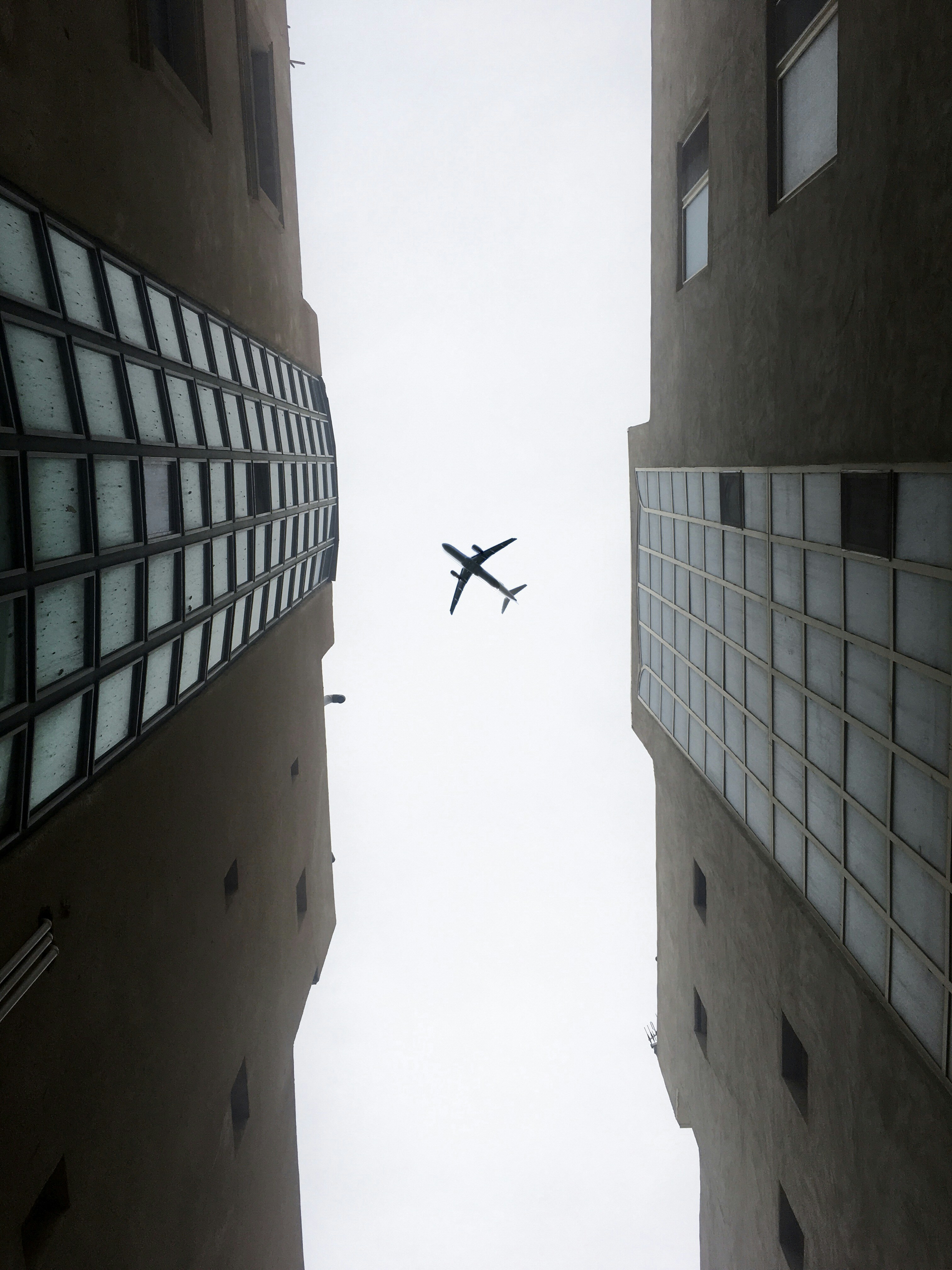 an airplane flying in the sky between two buildings