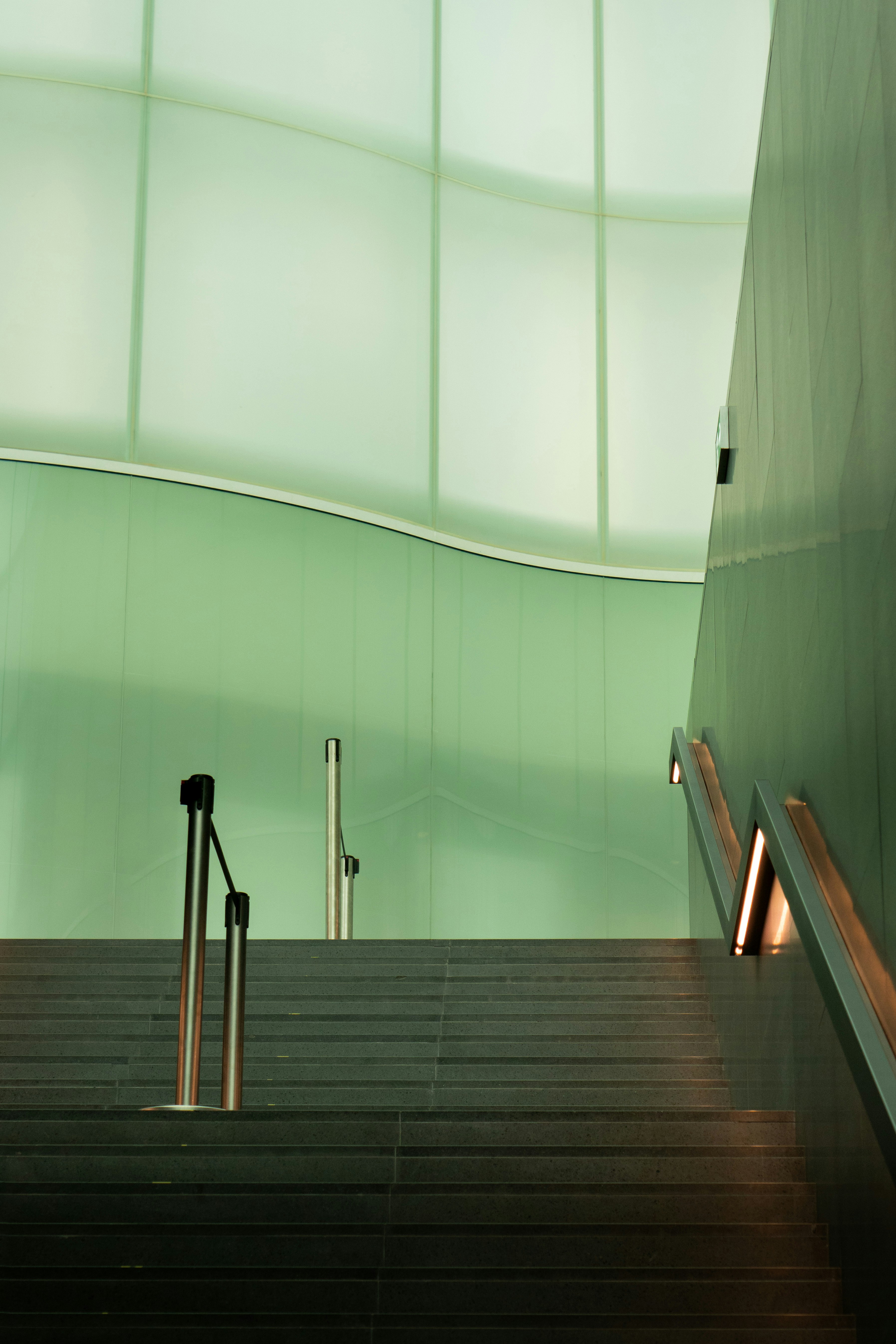 Una escalera mecánica en un edificio con una pared verde foto – Imagen ...