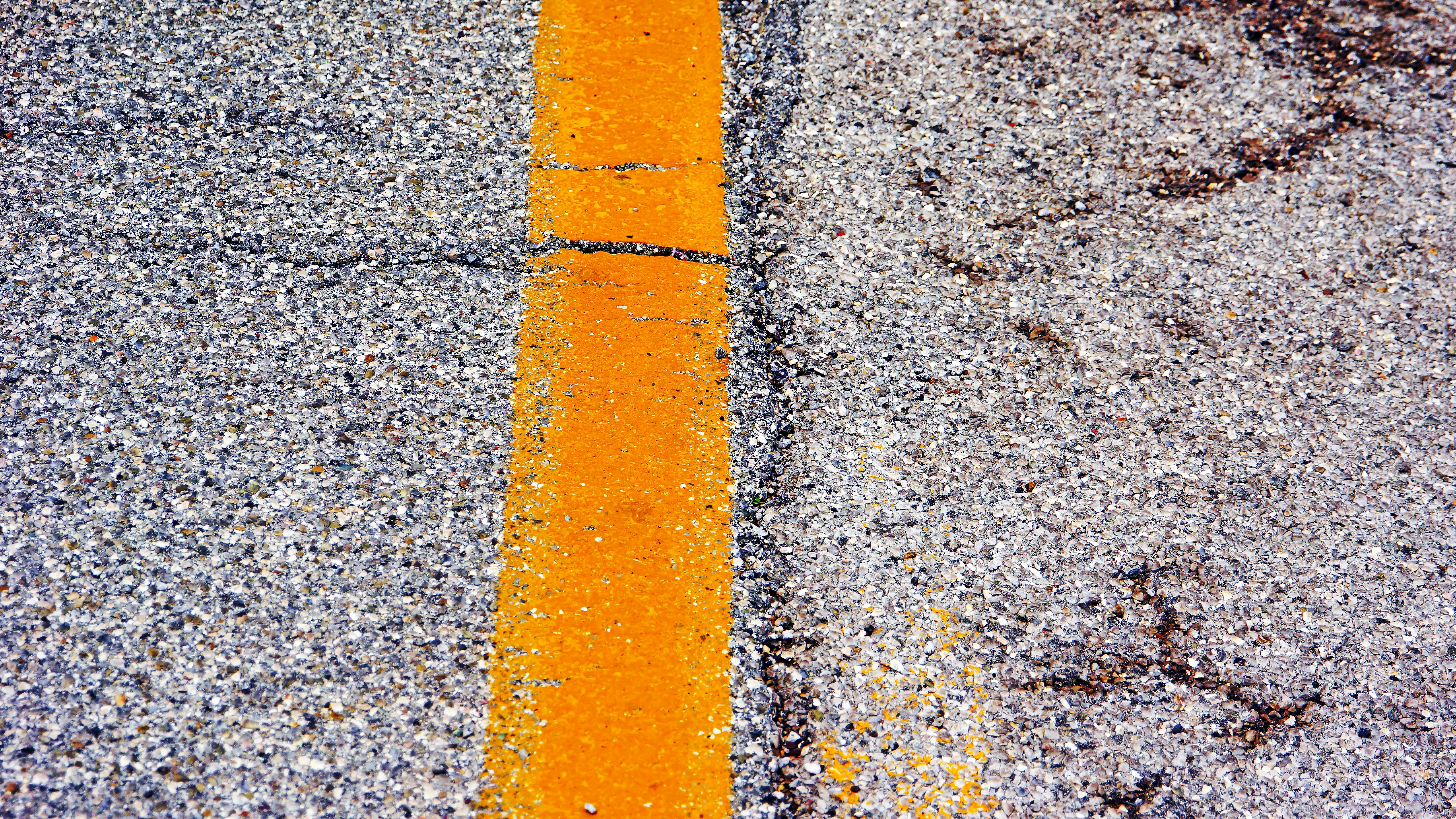 A yellow line painted on the side of a road photo – Free Orange Image ...