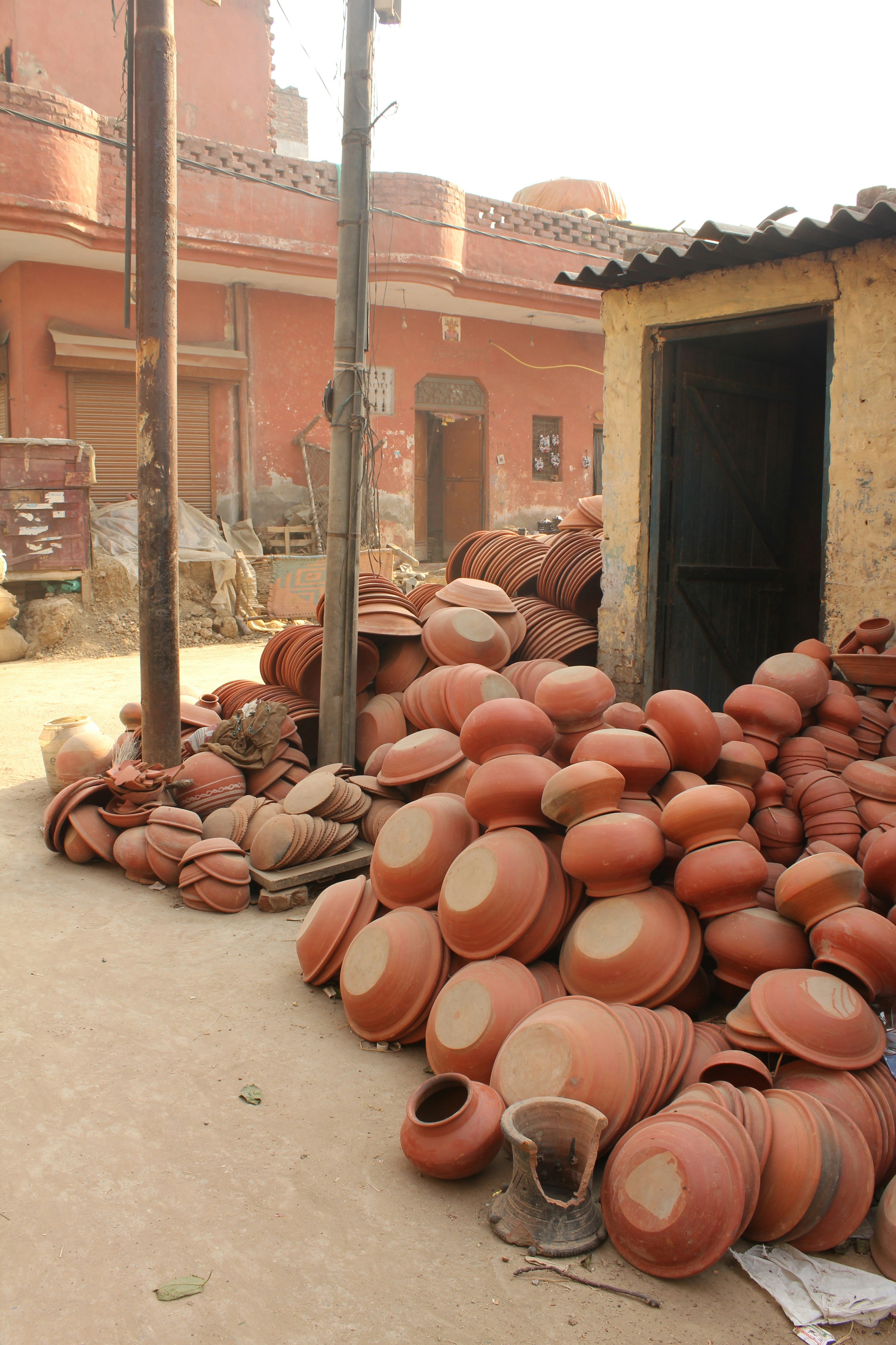 a pile of clay pots sitting in front of a building