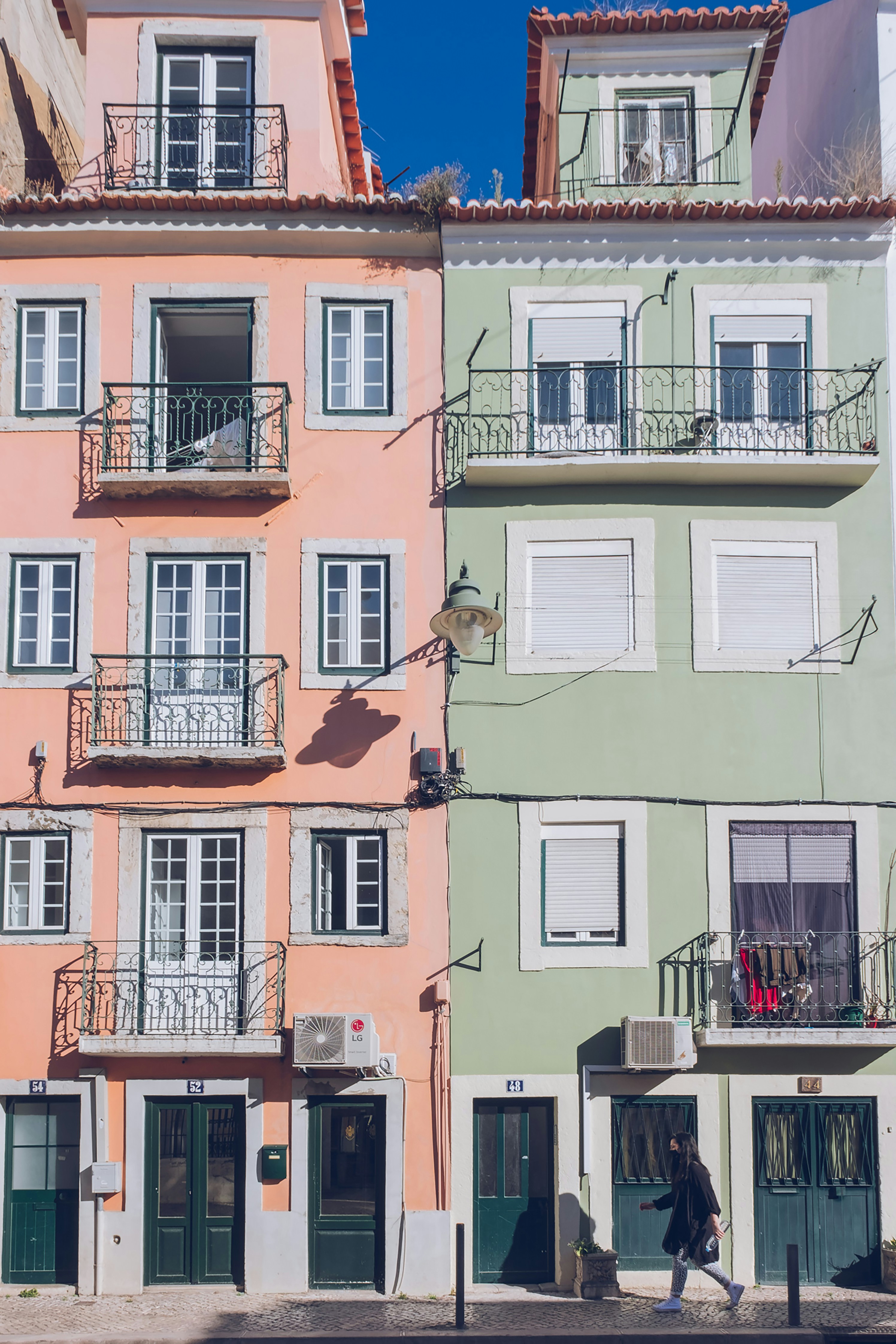 A person walking down a street past tall buildings photo – Free Lisbon ...