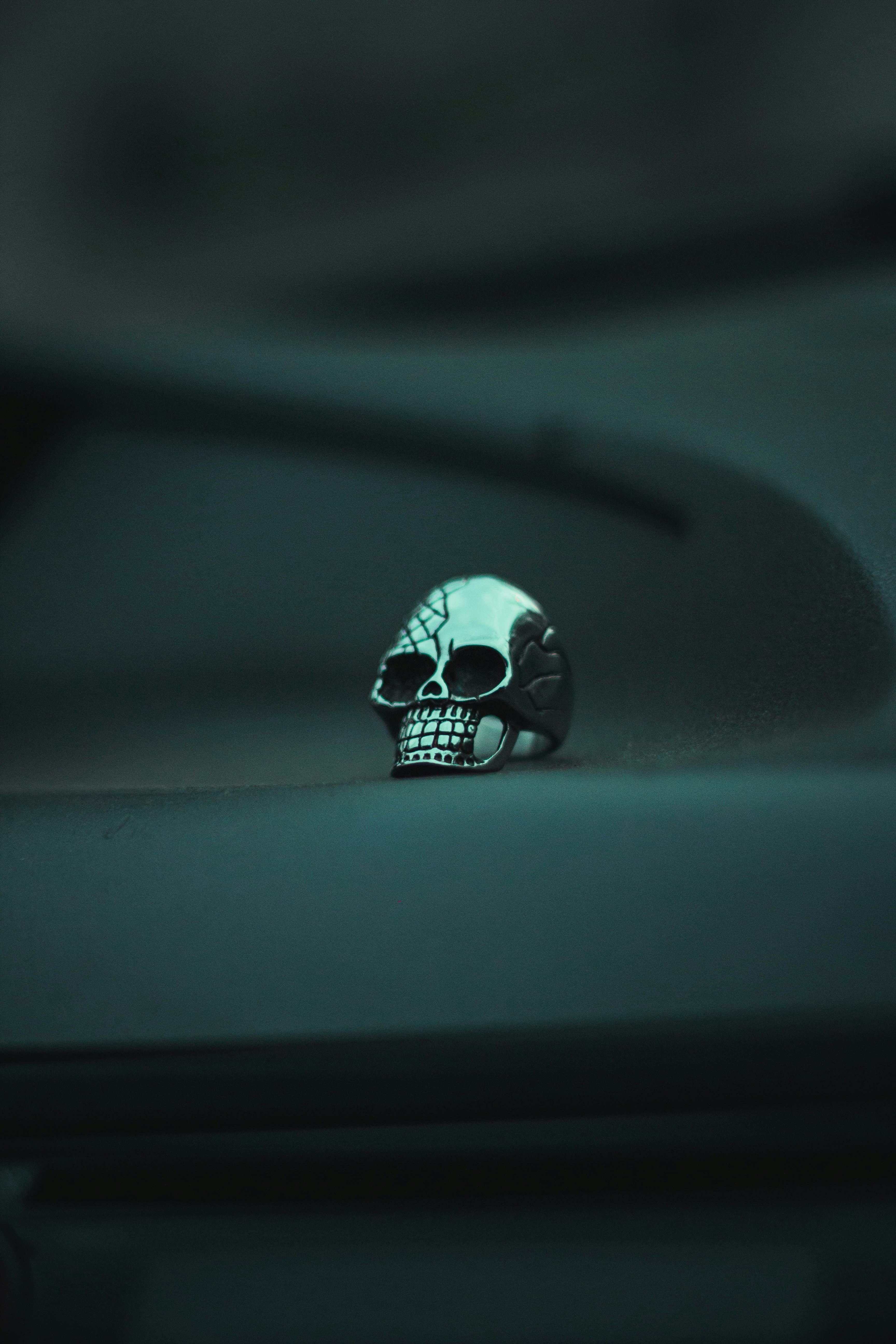 Teal Glint: A Tiny Skull on a Dim Dashboard