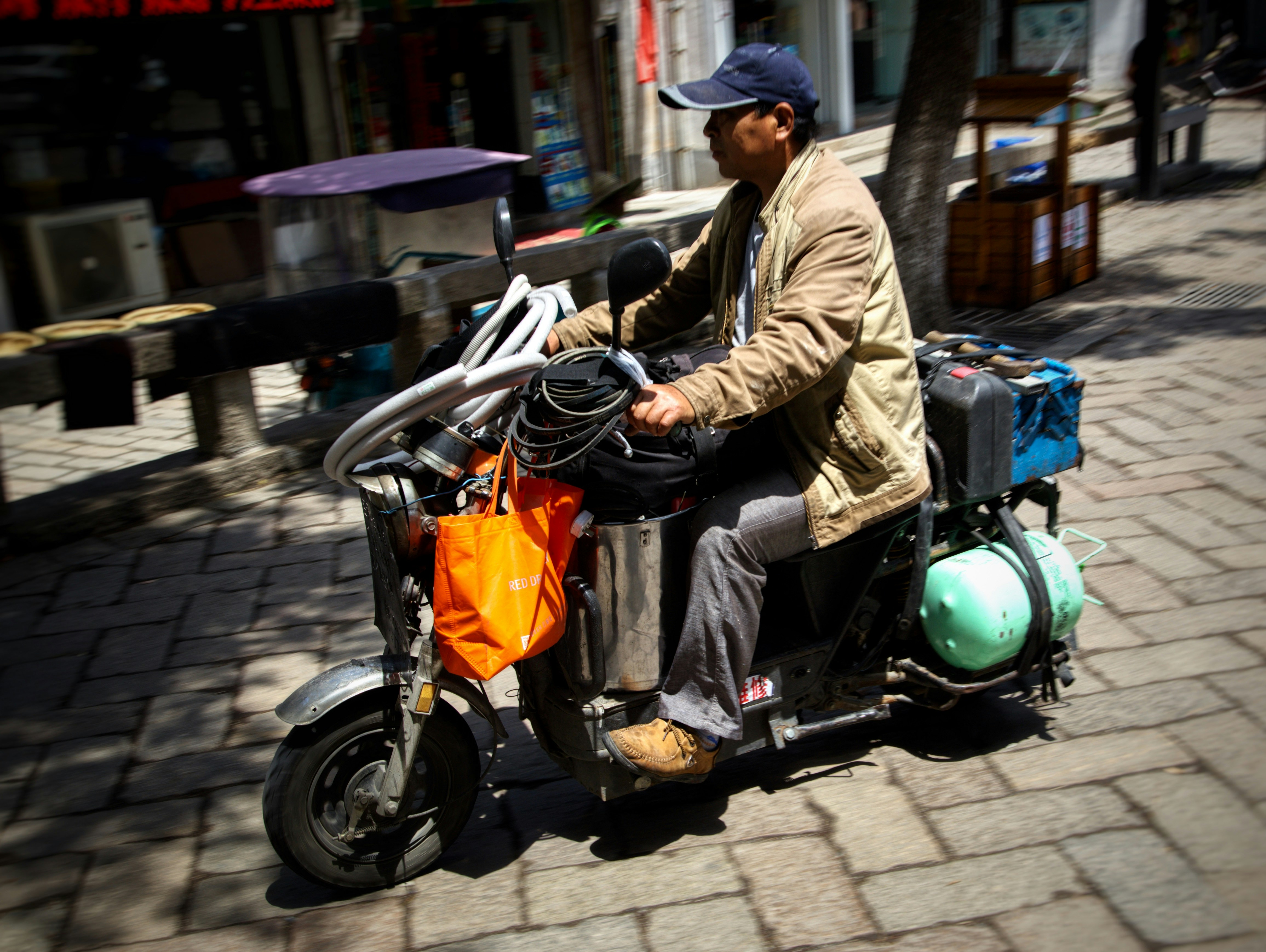 Market Street Glide: A Solo Rider on a Weathered Scooter