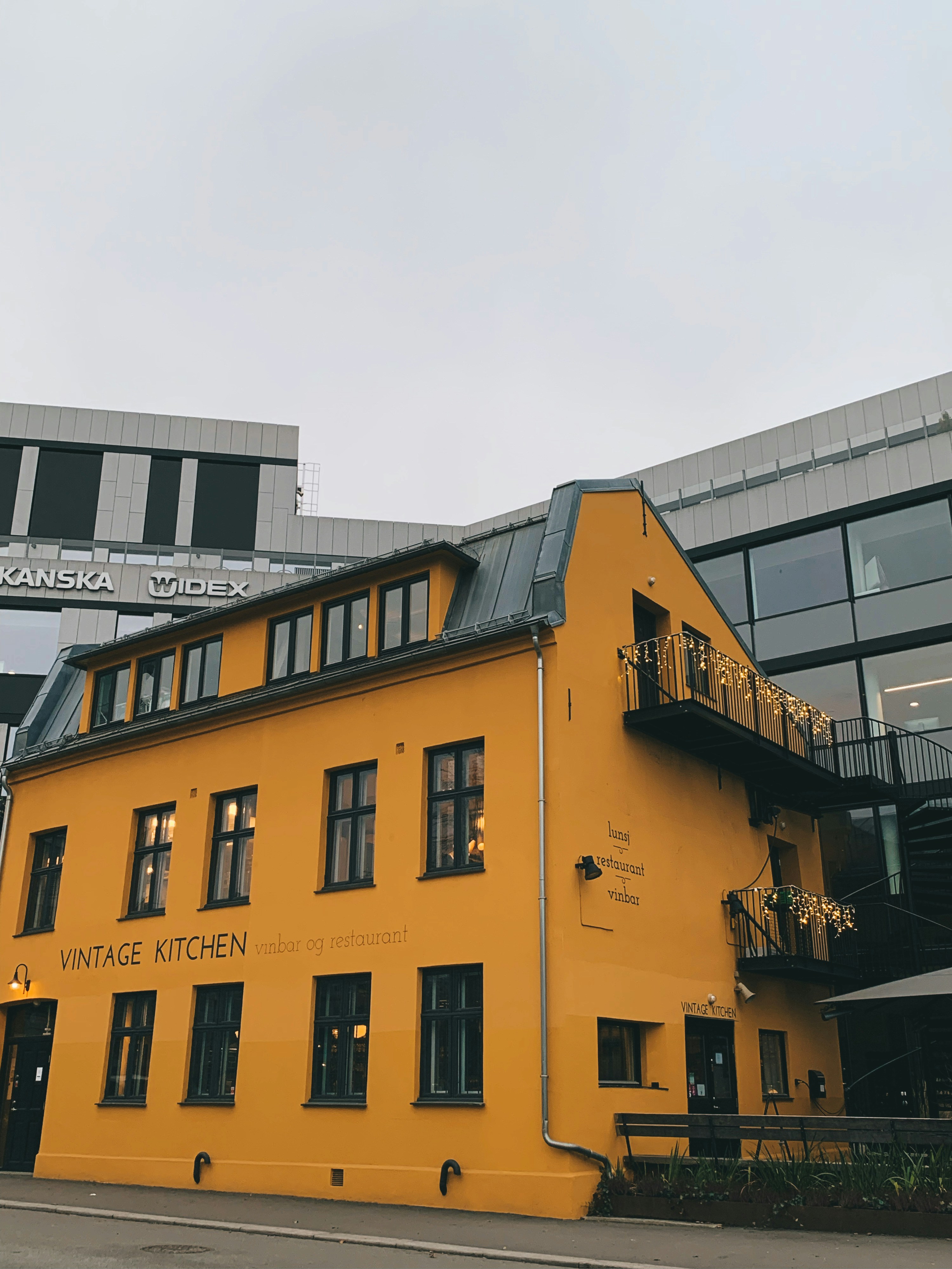 Yellow Facade Framed by Modern Glass: A Quiet Urban Contrast
