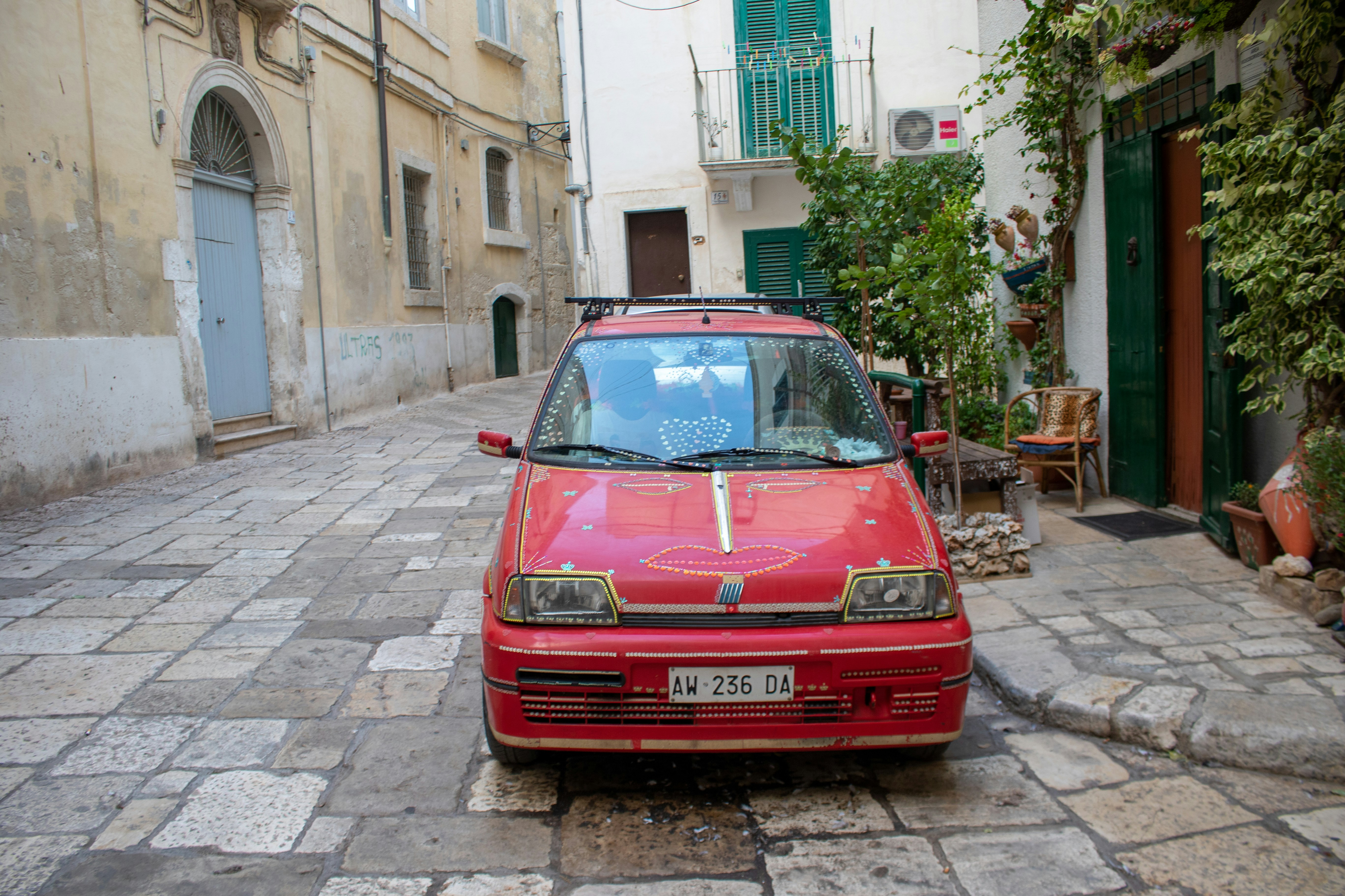 A small red car parked on a cobblestone street photo – Free Car Image ...
