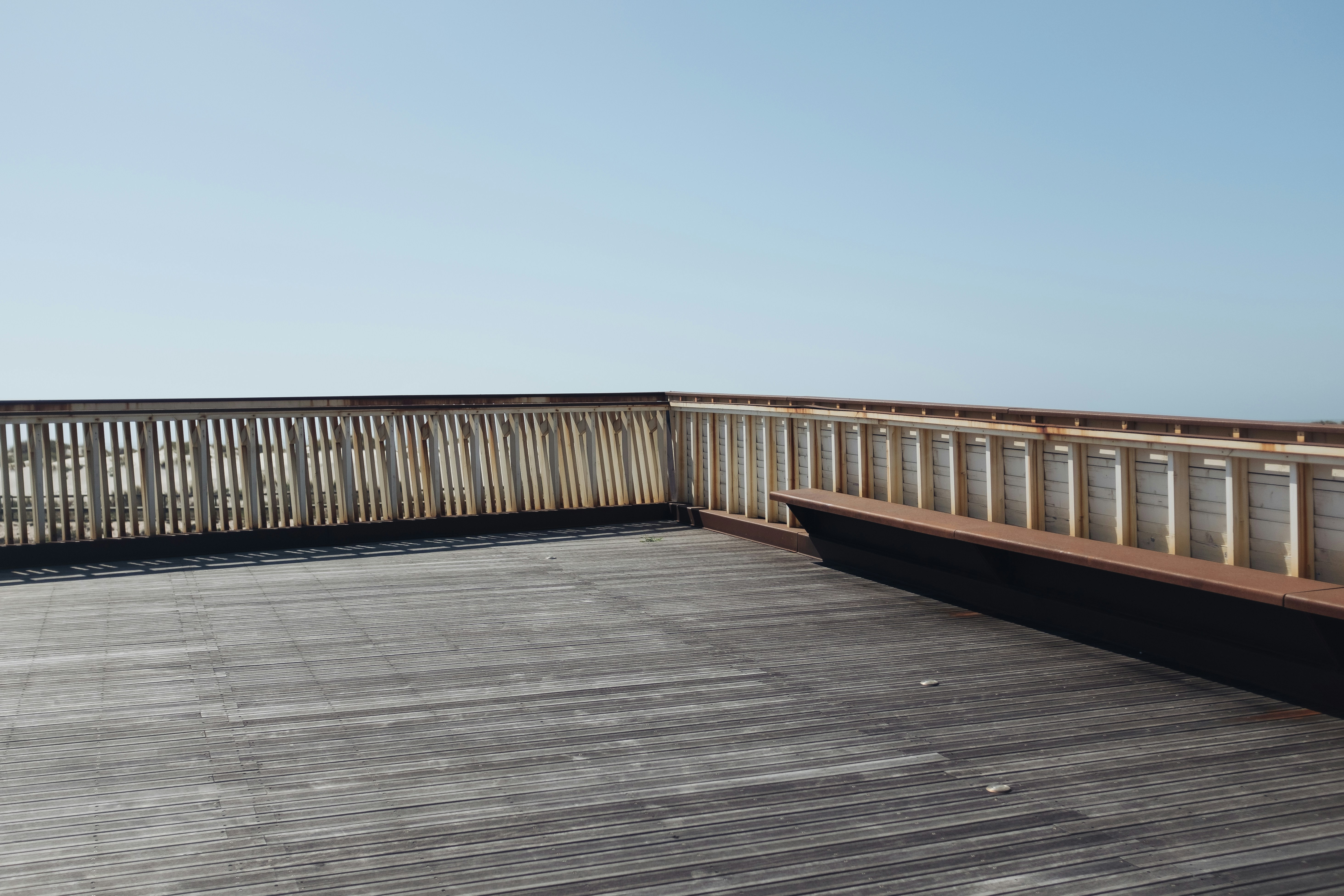 Vanishing Rails: A Sunlit Pier Extending Toward the Horizon