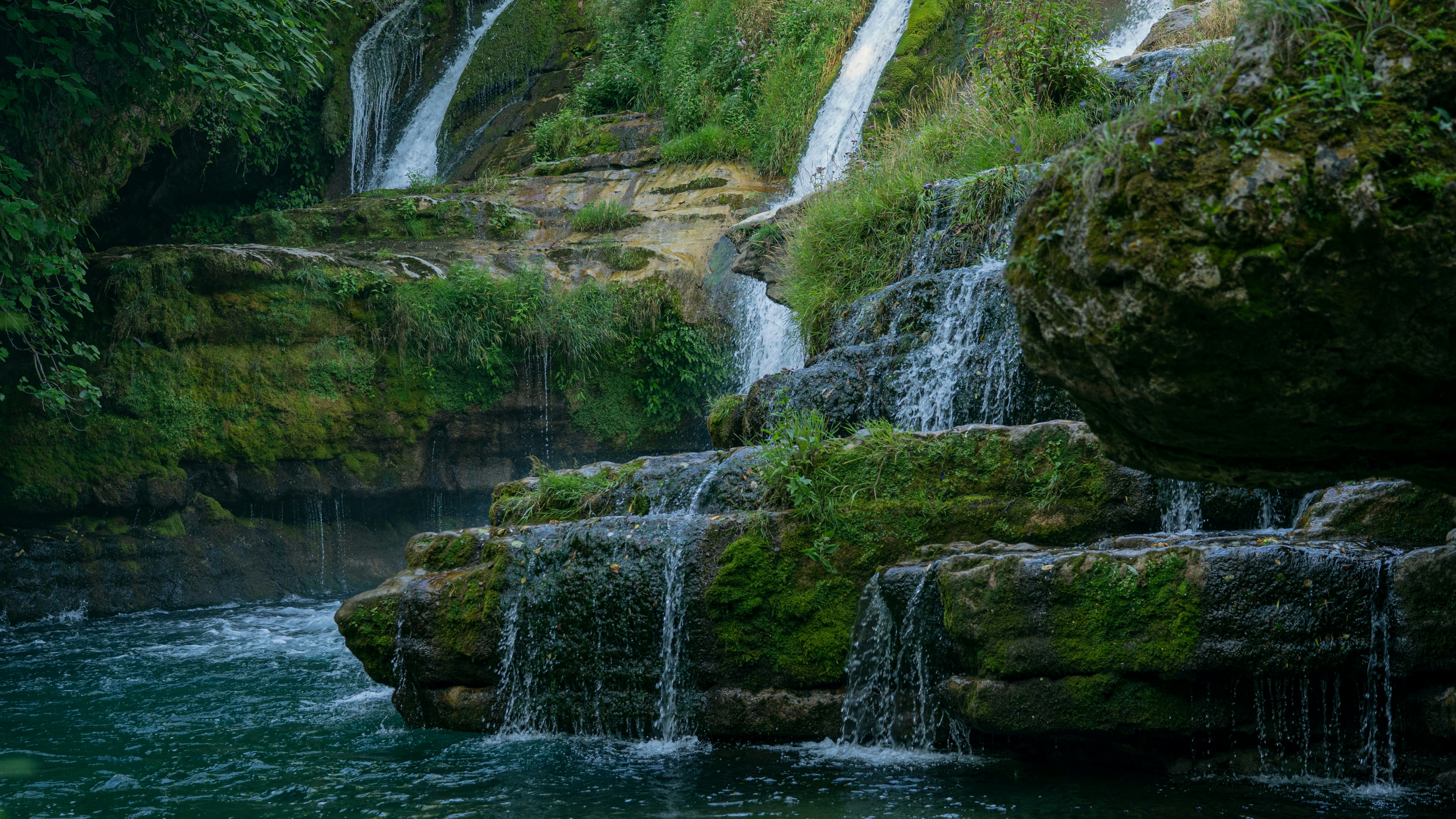 A group of waterfalls in the middle of a body of water photo – Free ...