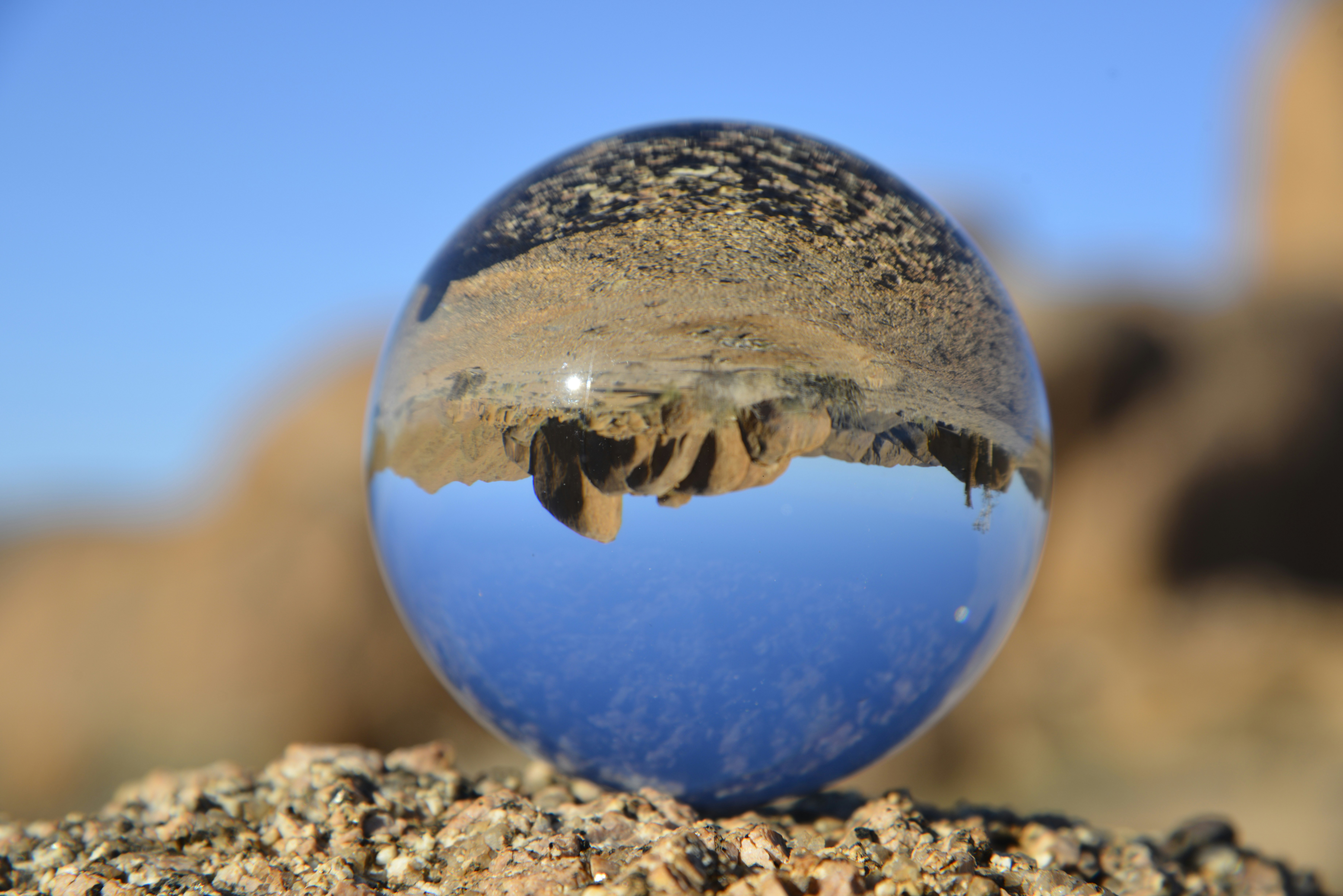 A Crystal Ball Reflects a Desert Landscape Up-close