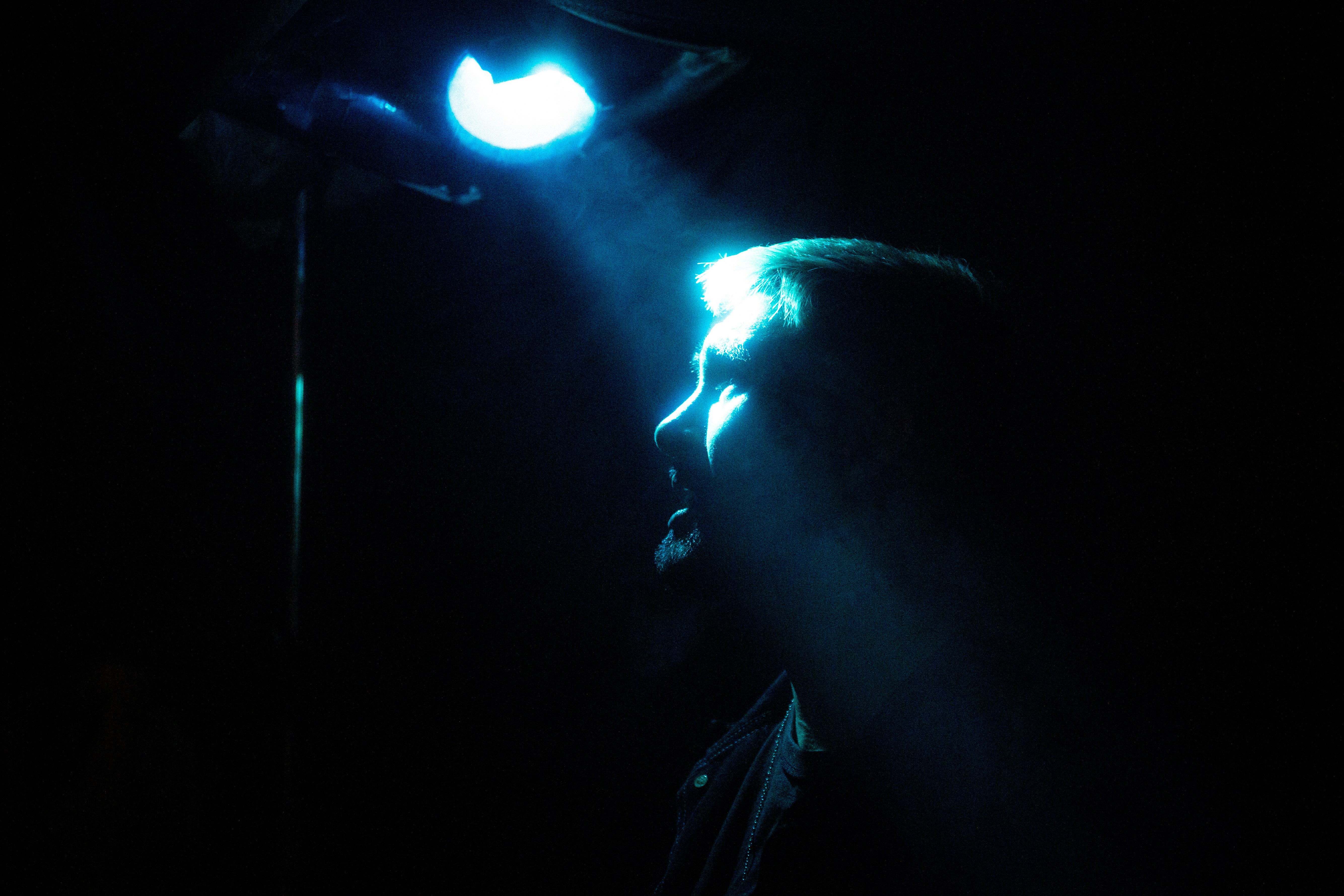 A person standing under a street light in the dark photo – Free Frame ...