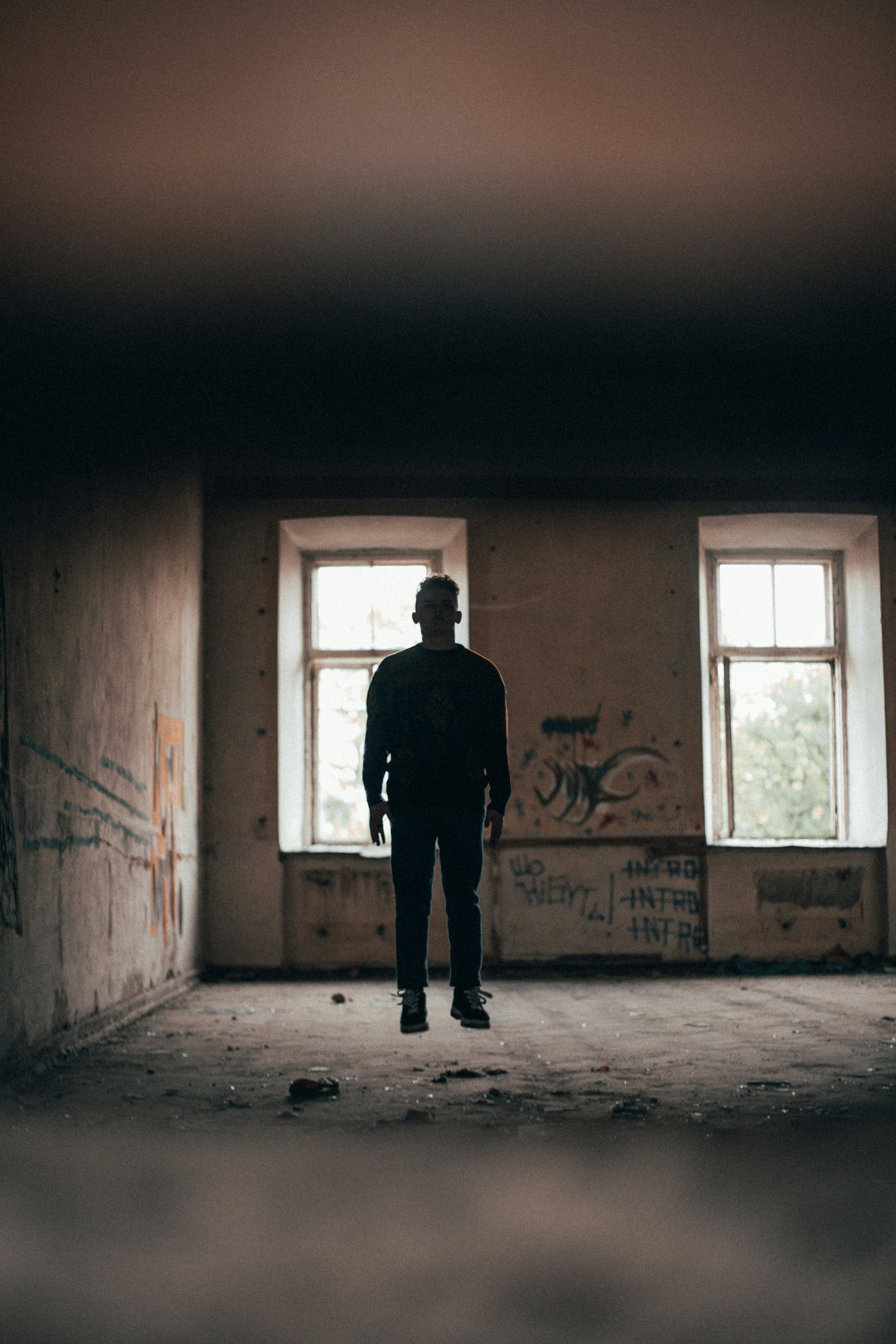 A man standing in an empty room with graffiti on the walls photo – Free ...