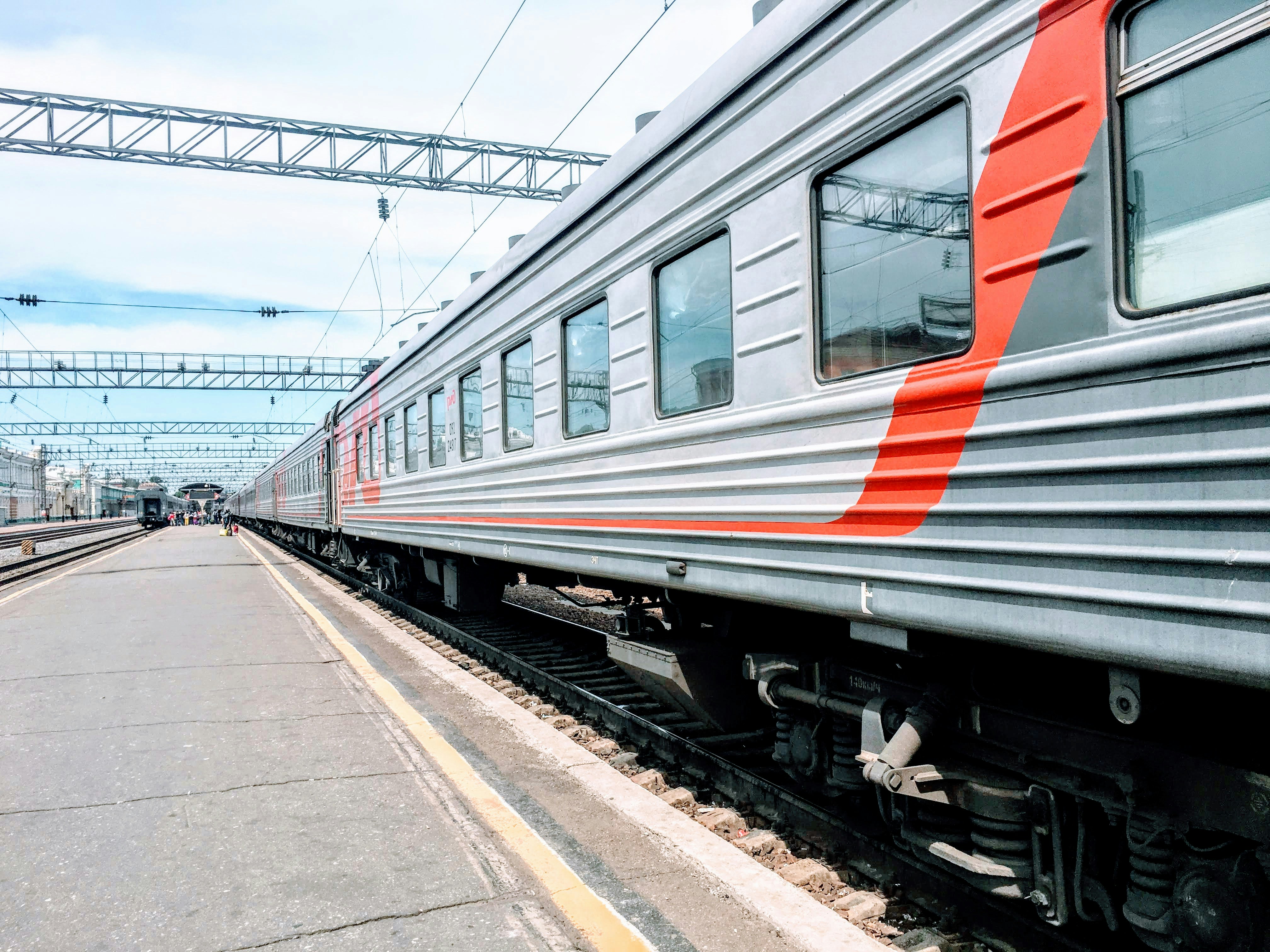 A red and silver train traveling down train tracks photo – Free Russian ...
