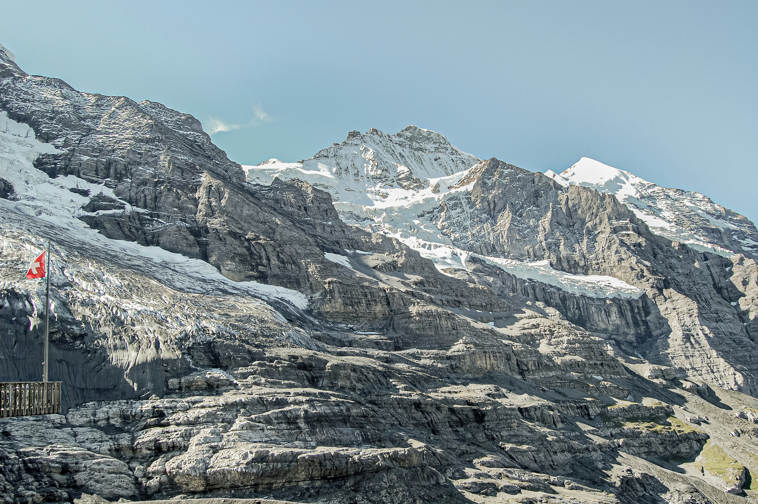 Lone Red Flag on a Granite Ridge Under a Clear Alpine Sky