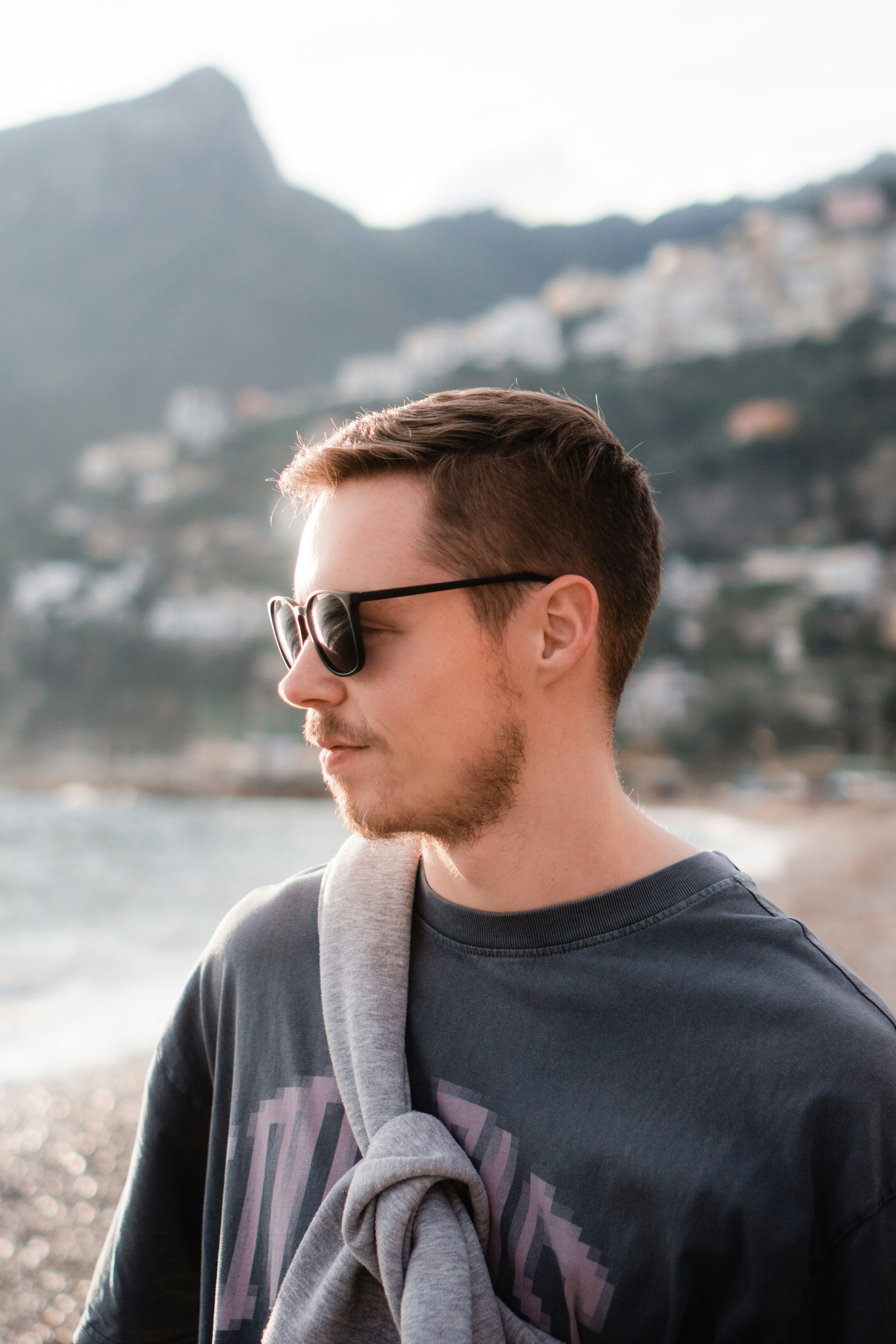 Sunlit Portrait on a Pebble Beach with Mountain Town Backdrop