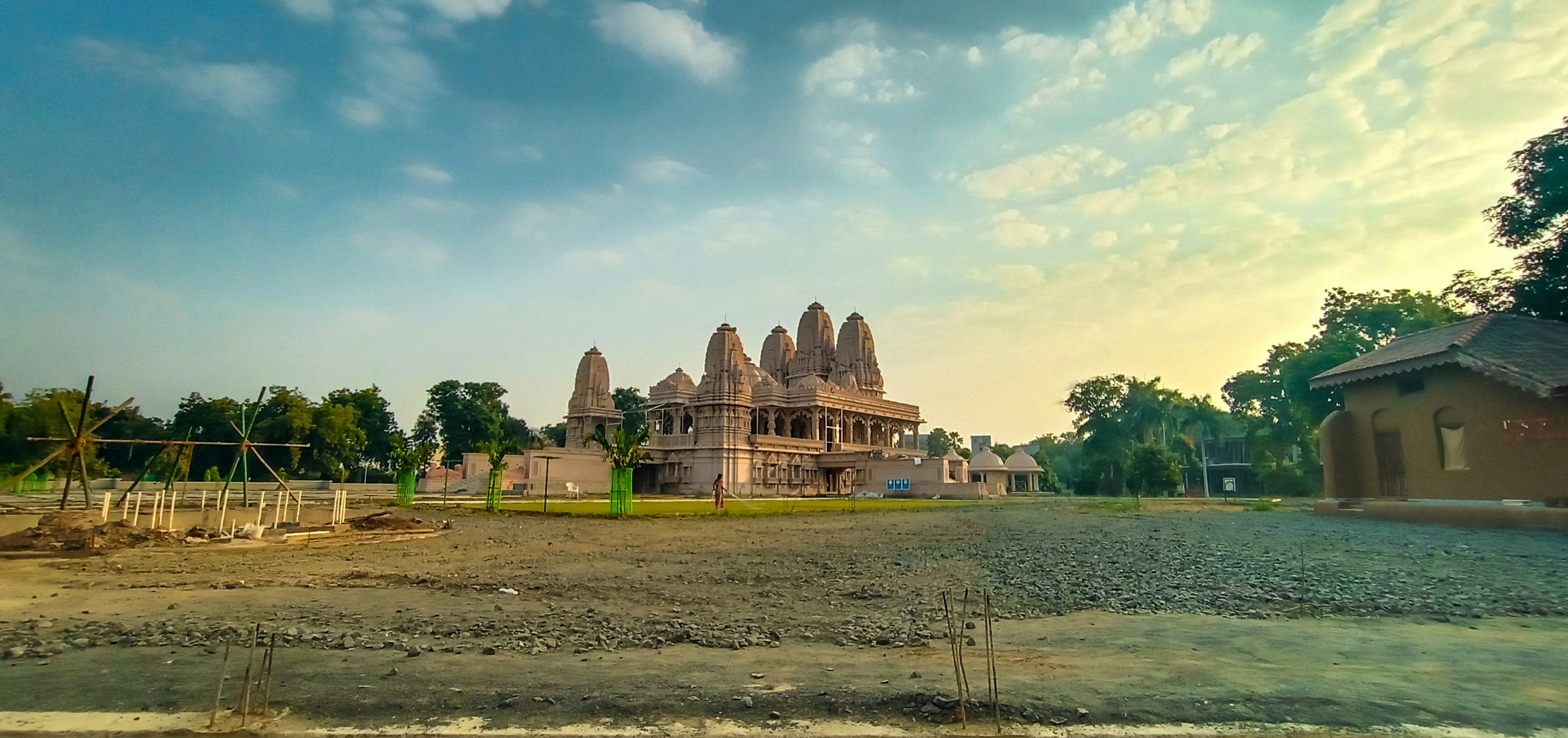 Intricate temple structure surrounded by lush greenery and a serene sky, showcasing architectural beauty and historical significance.