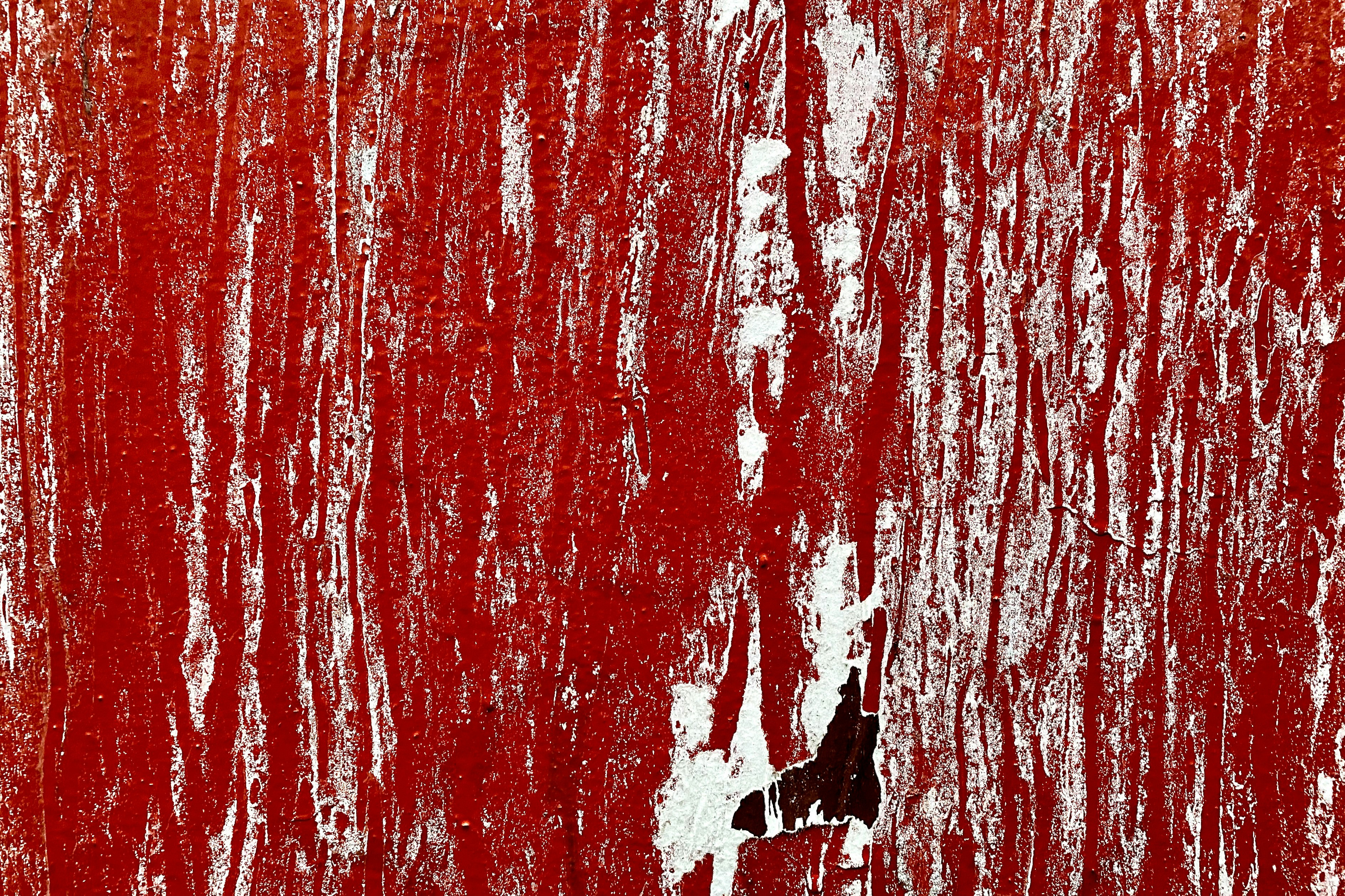 a red wall with white paint on it