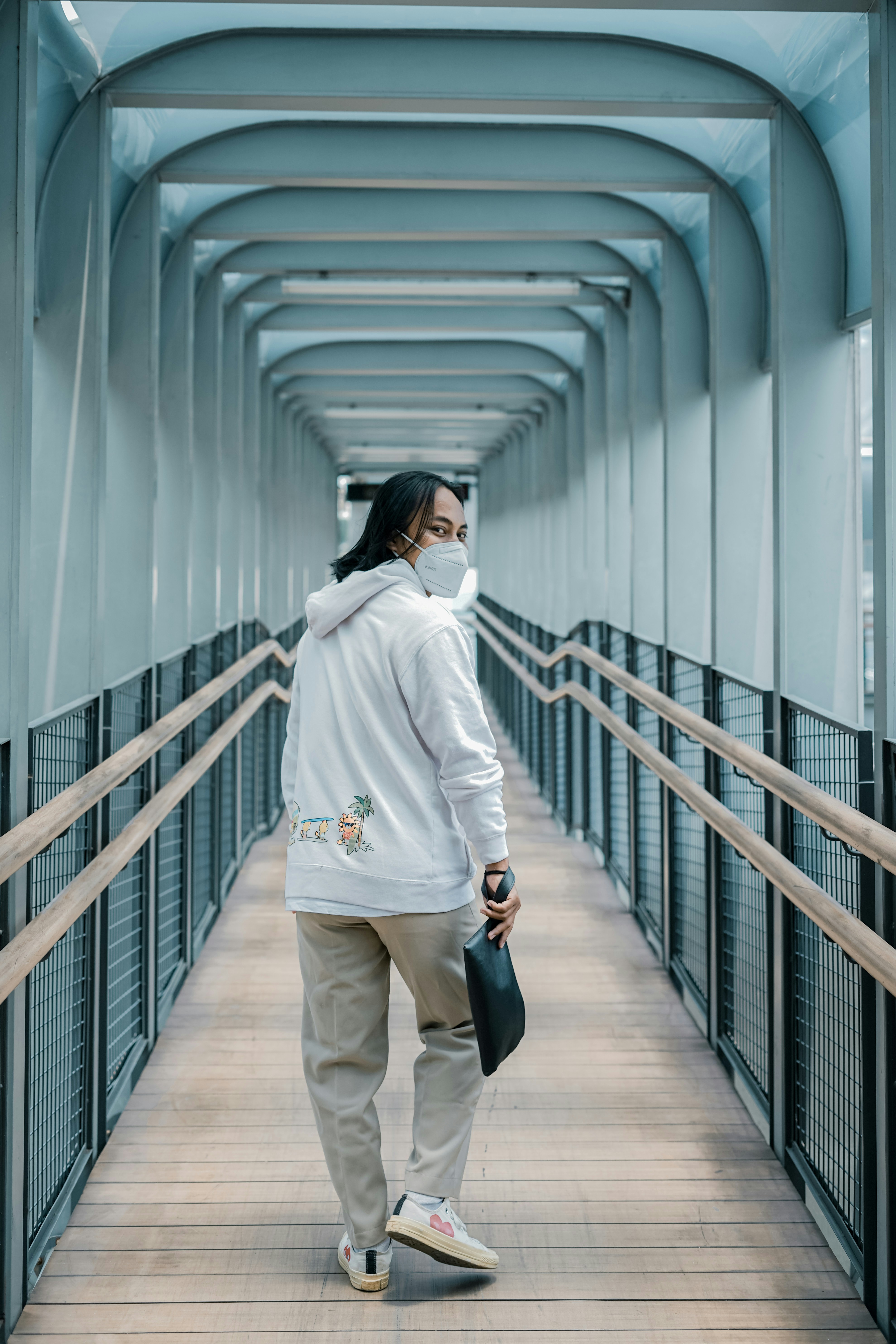 Turned Back on a Turquoise Walkway: A Quiet Portrait in Transit