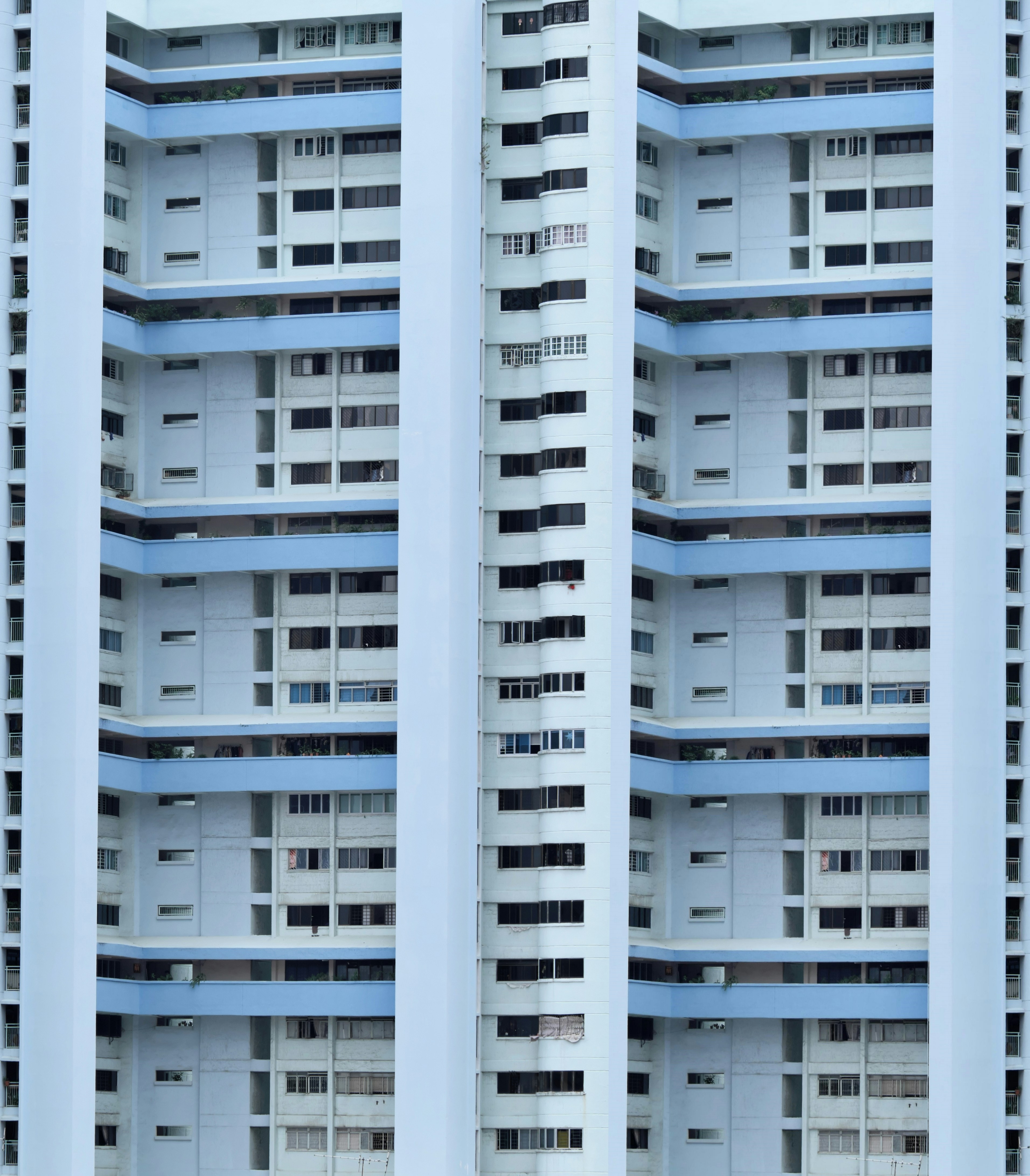 Modern residential building facade showcasing repetitive architectural patterns and a cool color palette.