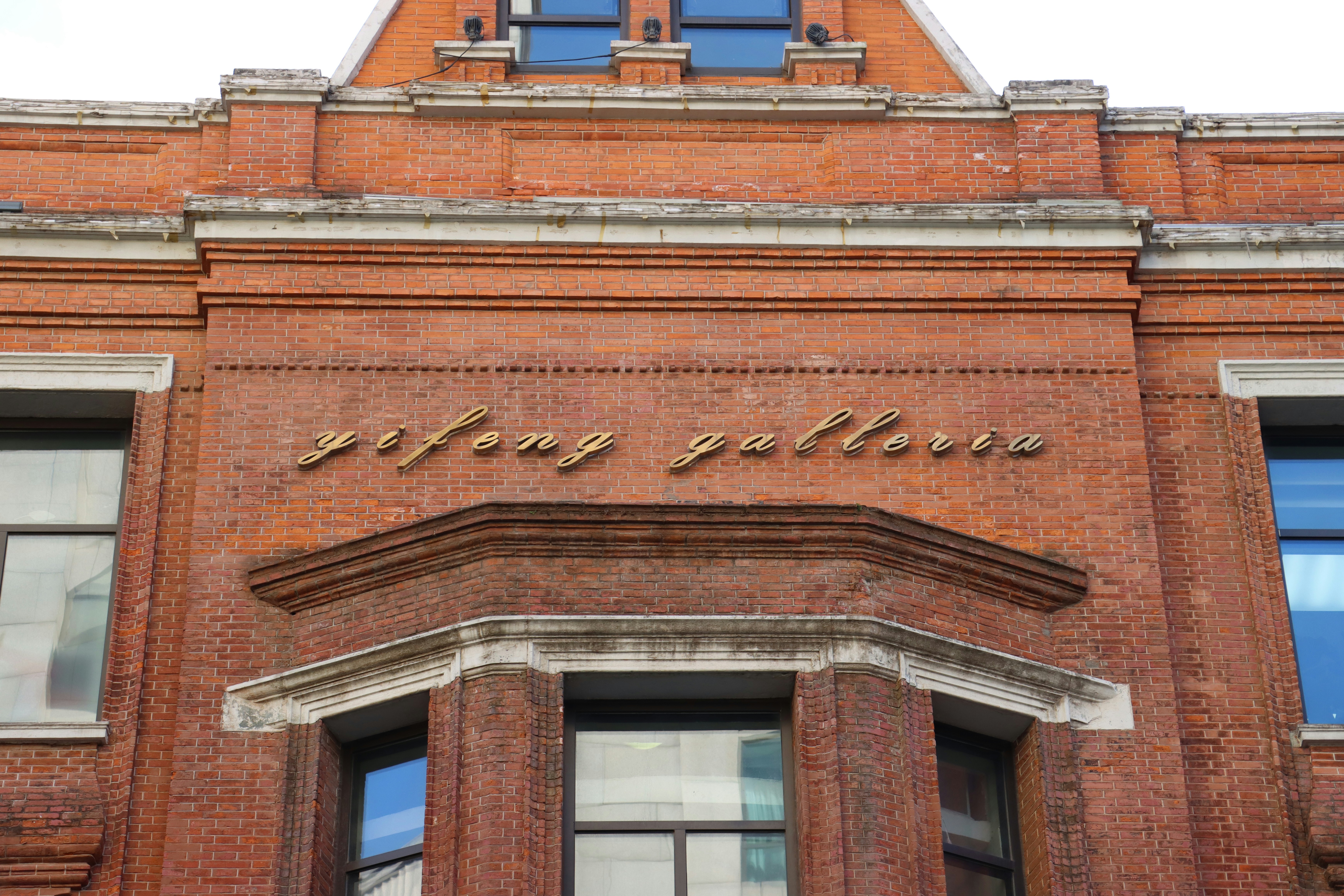 Gold Script Over Red Brick: The Corner Facade of a Historic Galleria