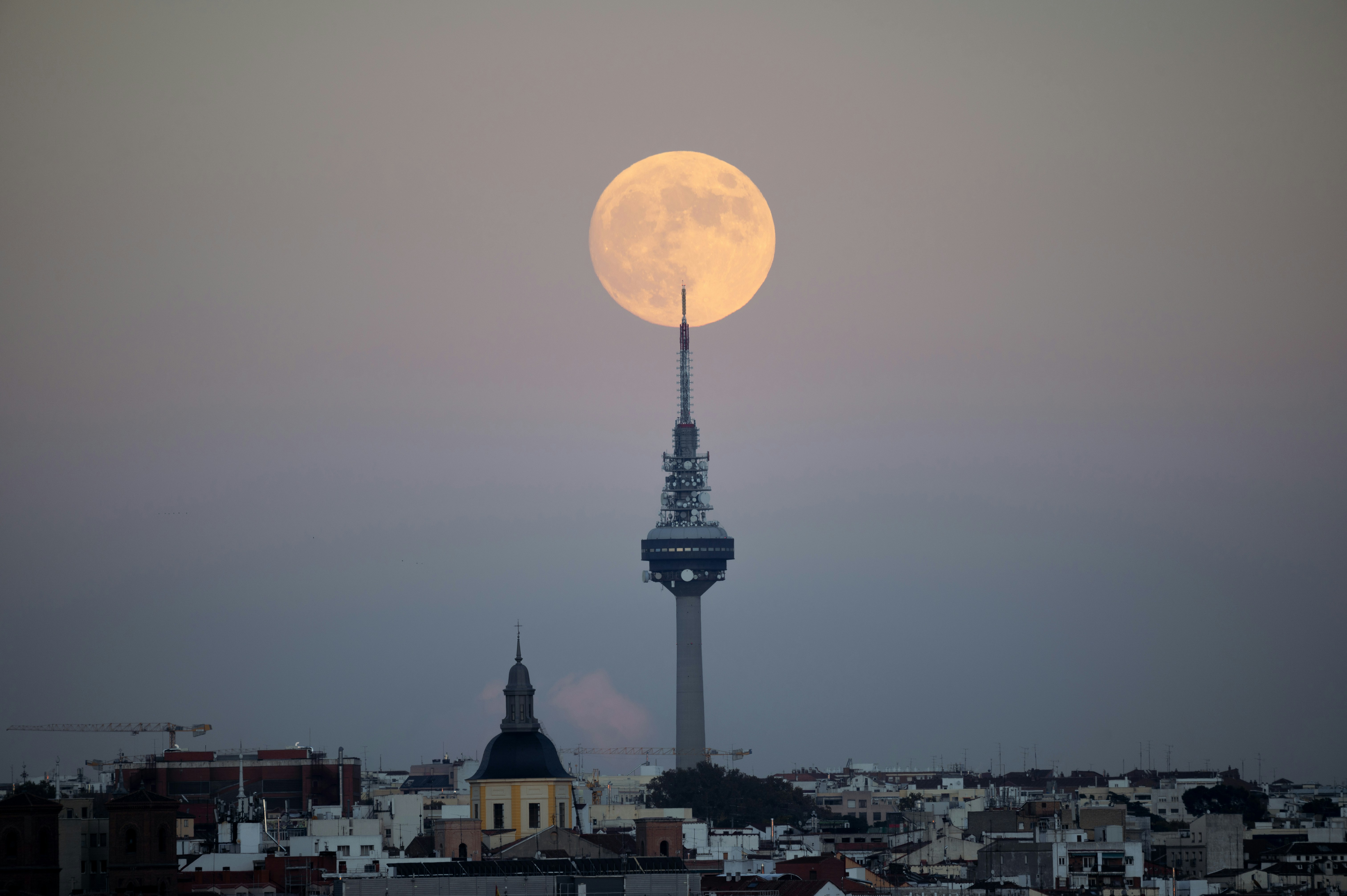Una luna llena se eleva sobre el horizonte de una ciudad foto – Imagen ...