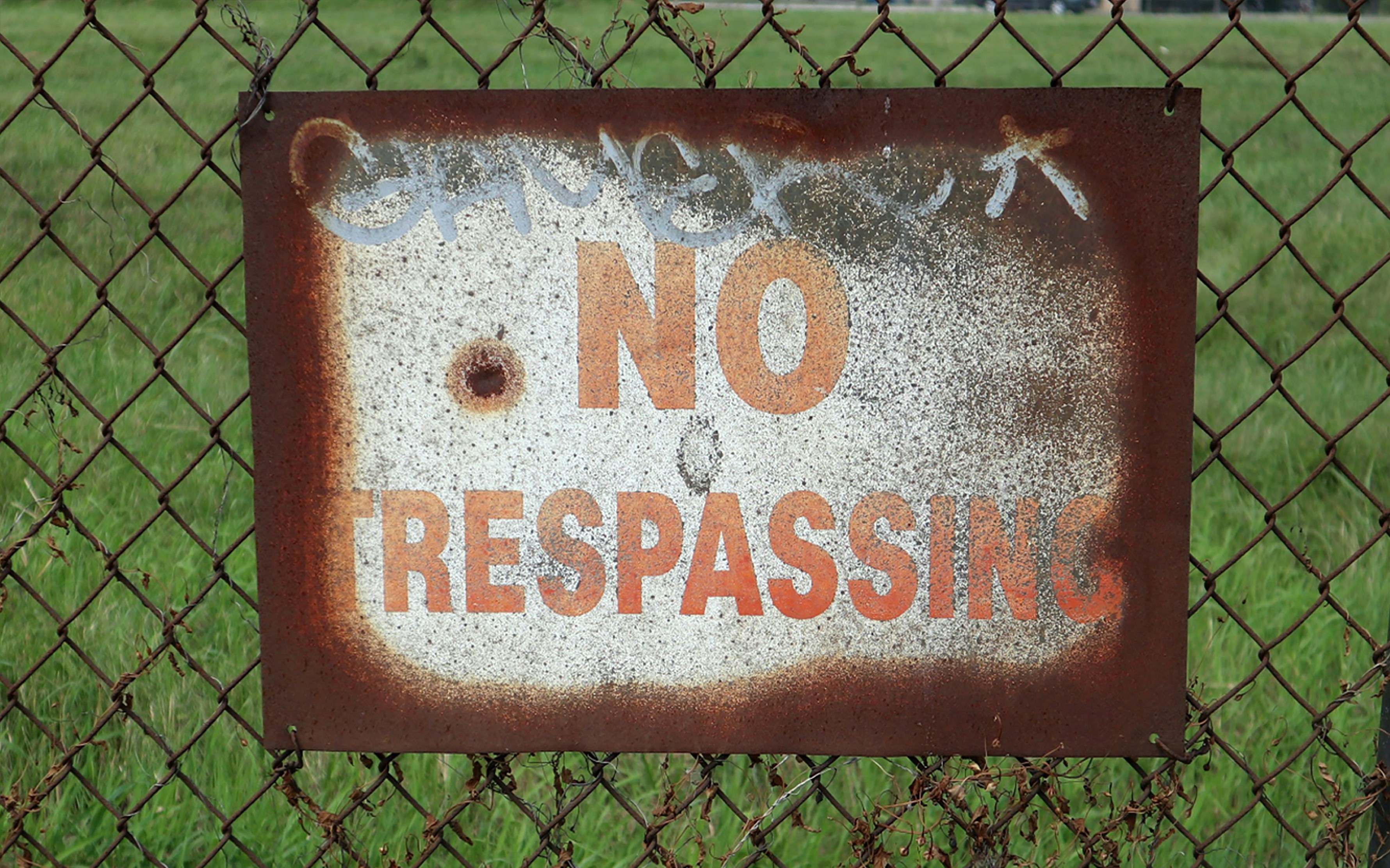 A rusted no trespassing sign on a chain link fence photo – Free ...