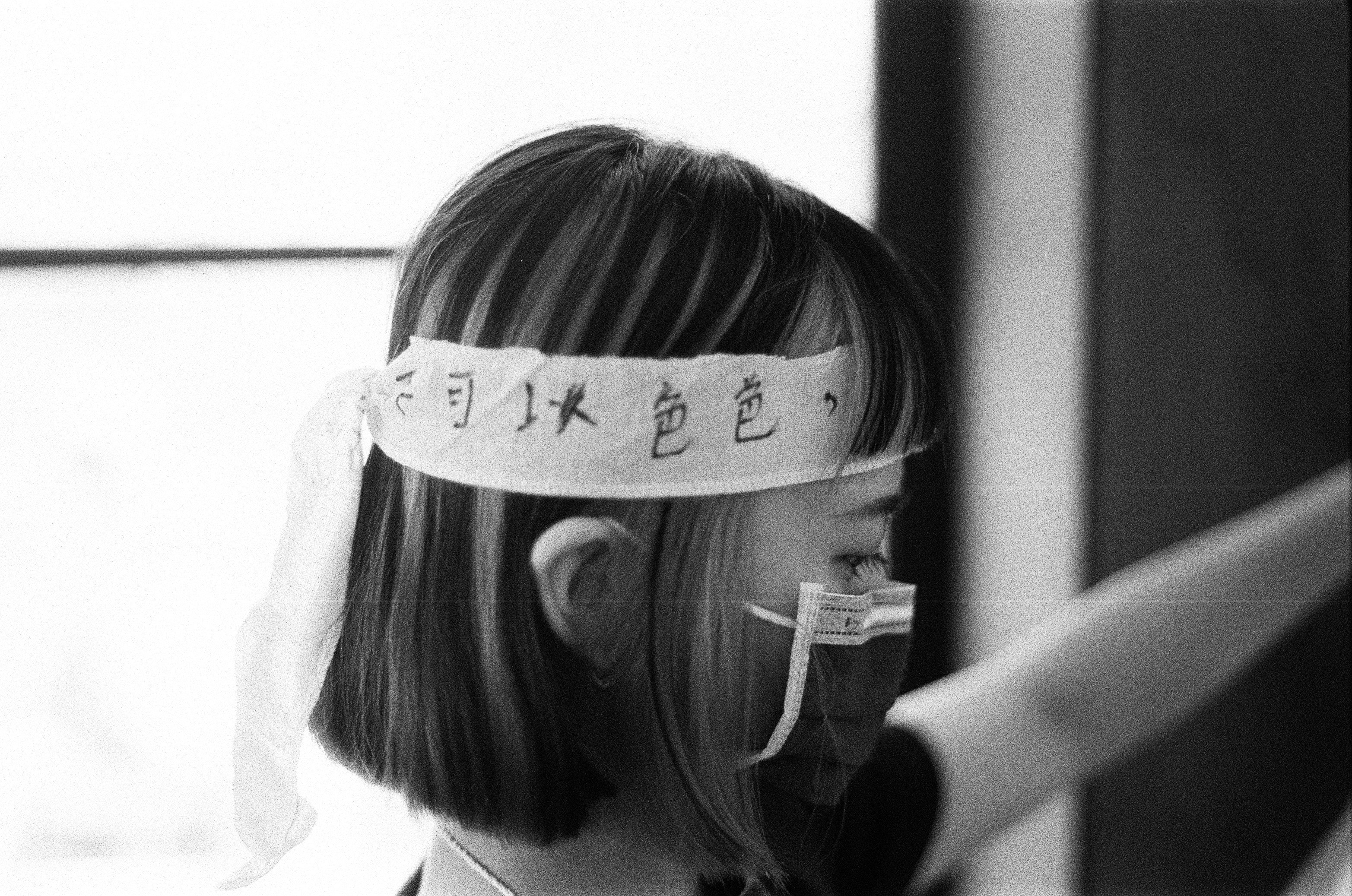 A young girl wearing a blindfold with writing on it photo – Free Film ...