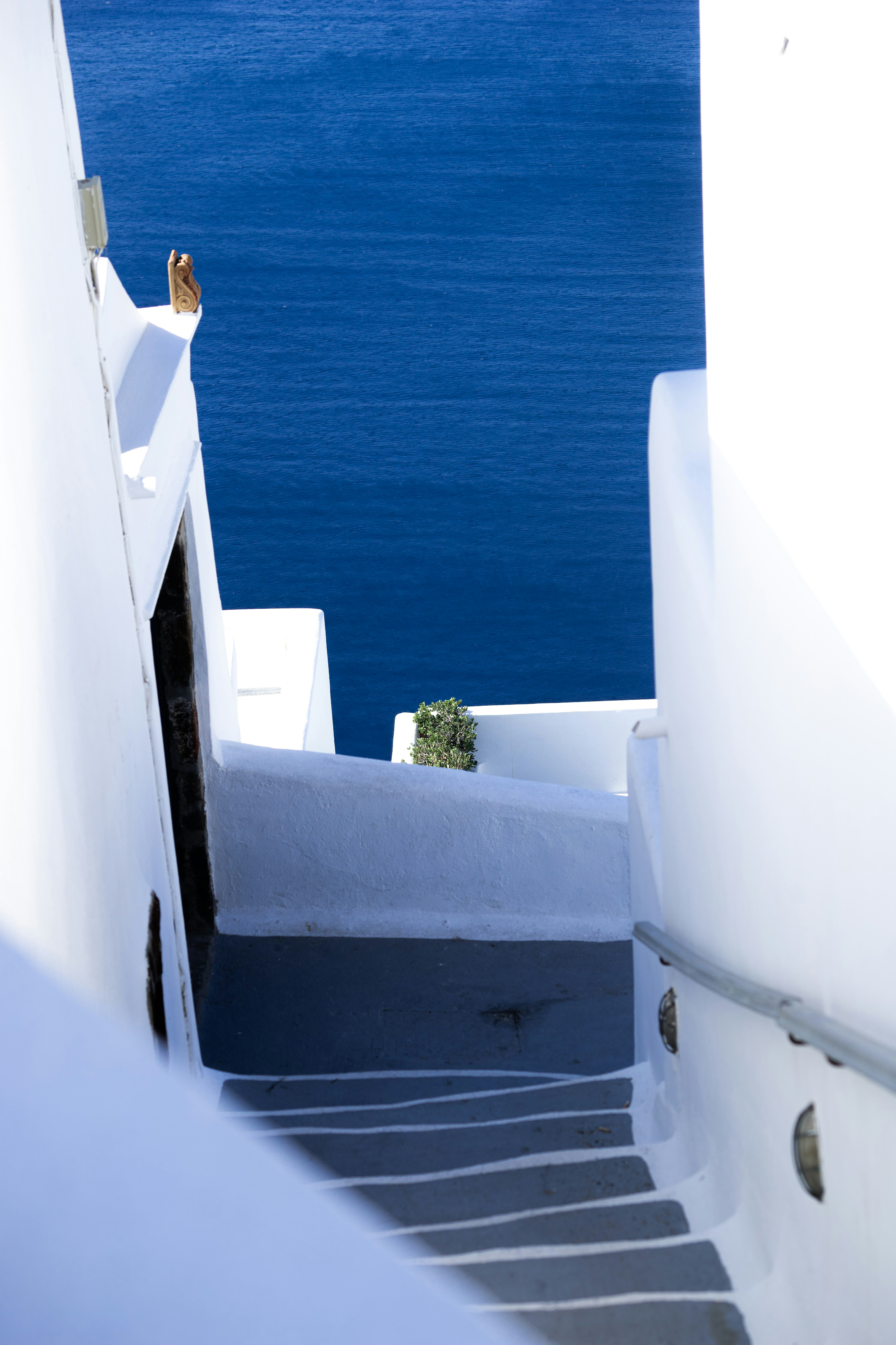 Stairwell to Azure: White-Washed Walls Framing the Sea