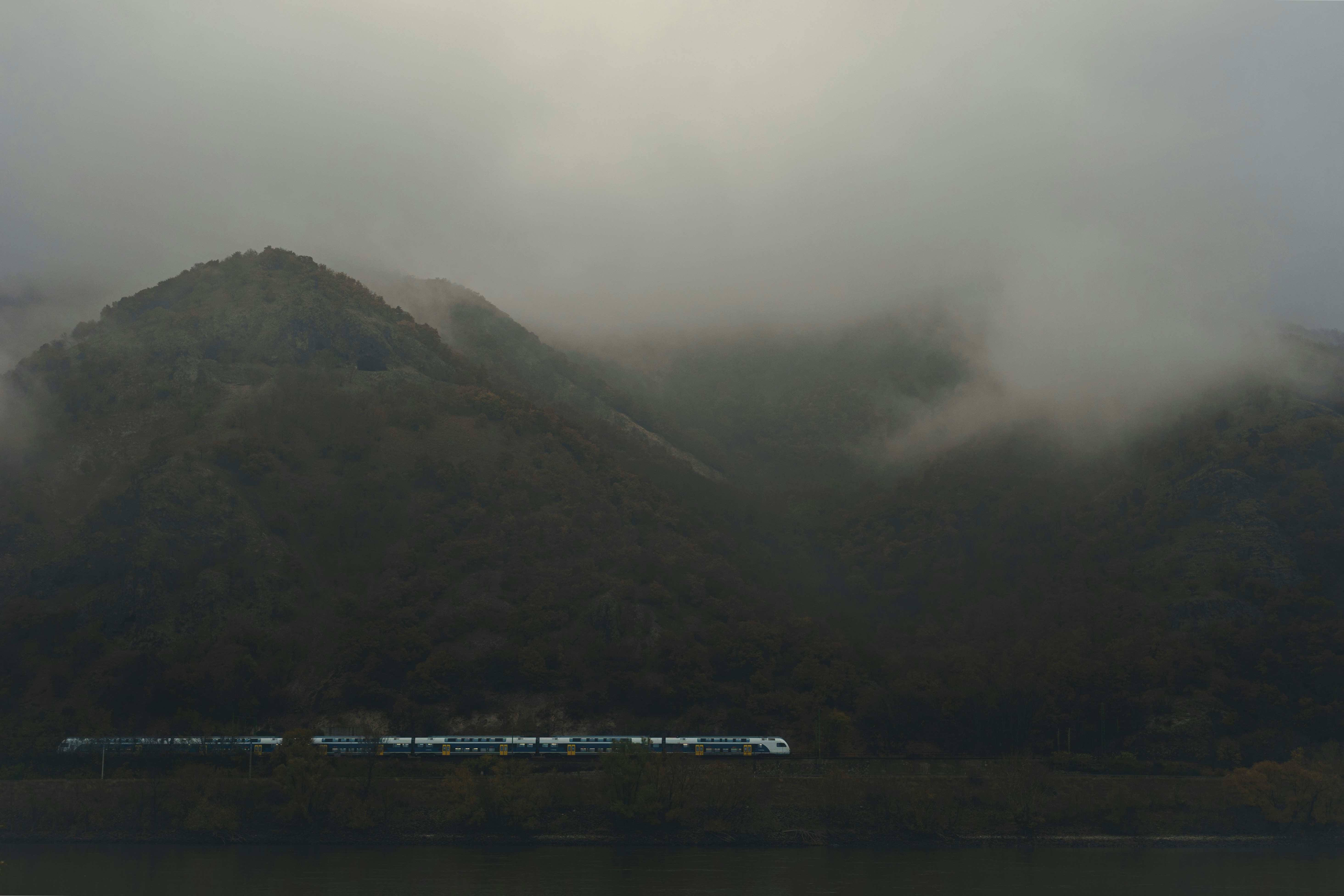 Un tren en una vía de tren cerca de un cuerpo de agua foto – Imagen de ...