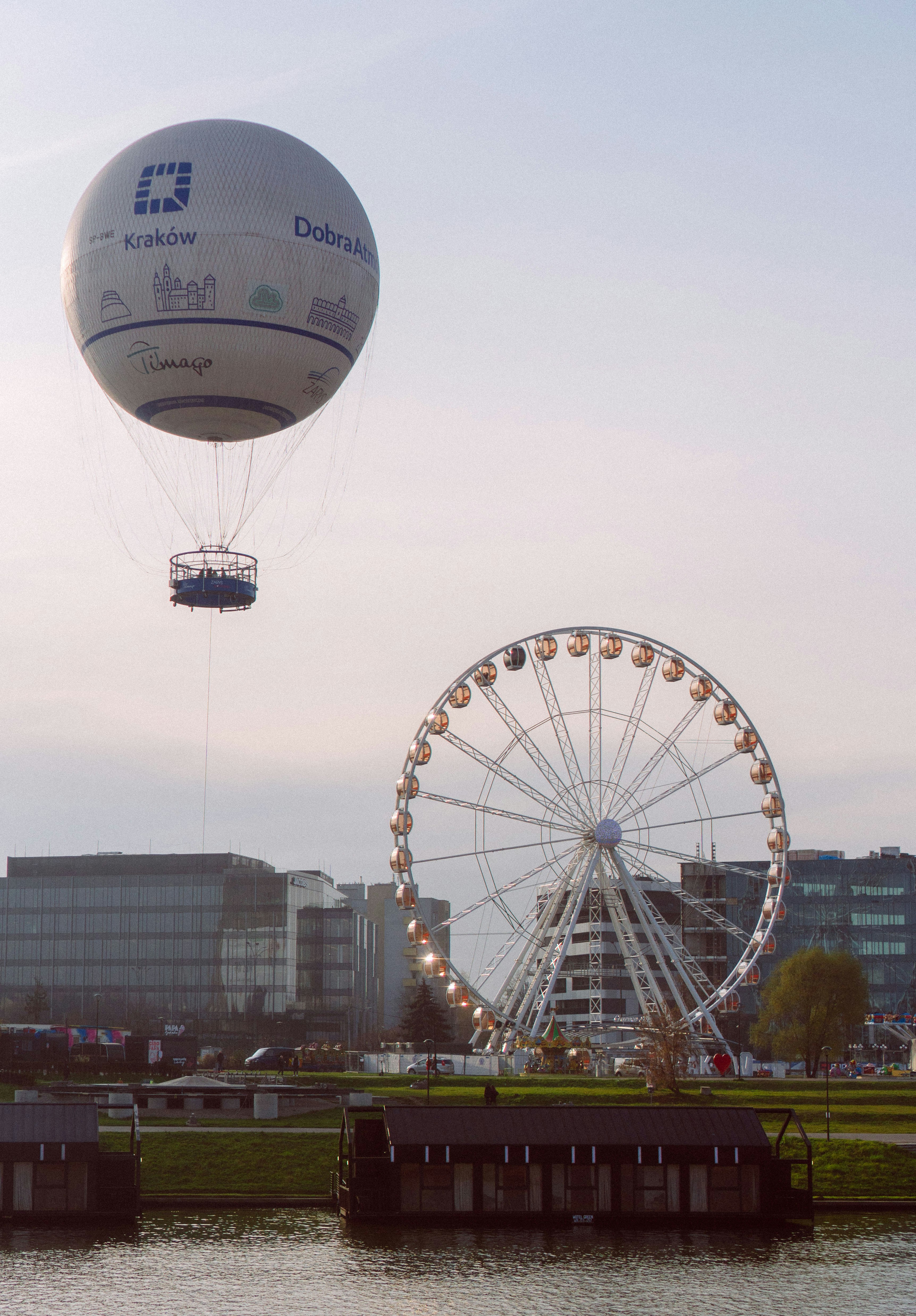 Balloon Lift Over Kraków's Riverside: Dawn Light Framing a Giant Ferris Wheel