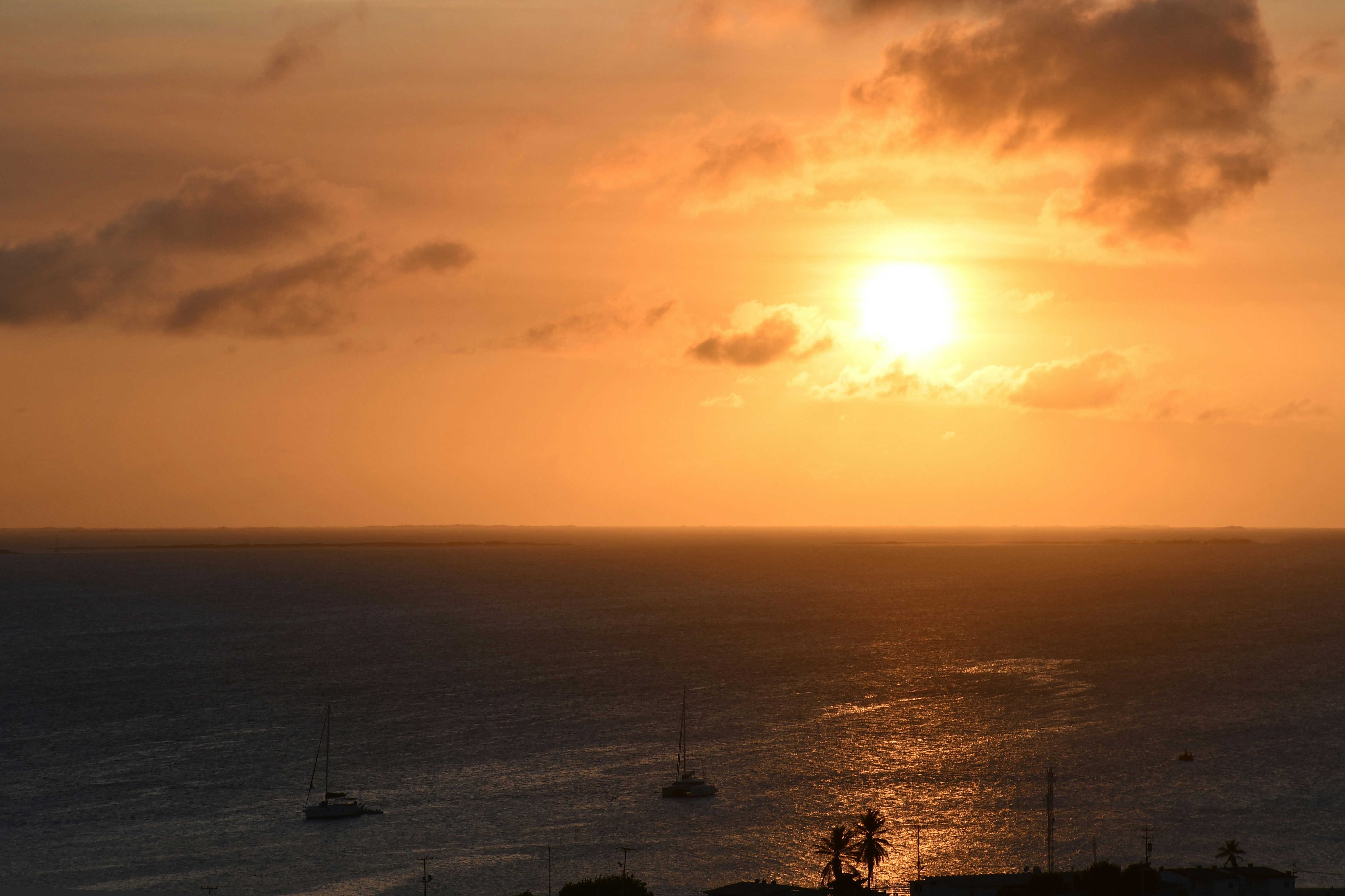 Ember Horizon: Sailboats Glide Beneath a Peach Sky