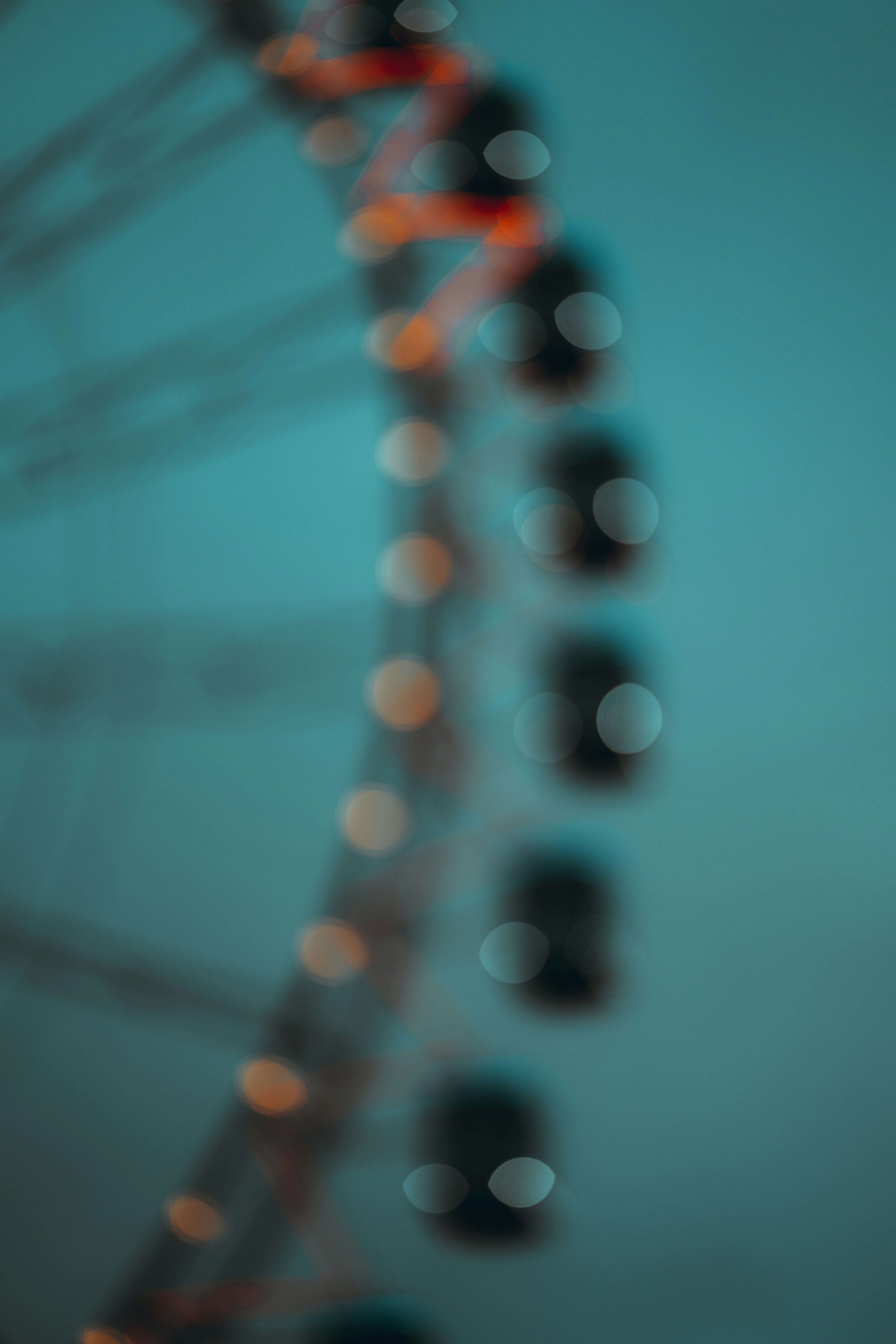 Blurry Ferris Wheel Bokeh: Circular Orbs in Twilight Teal