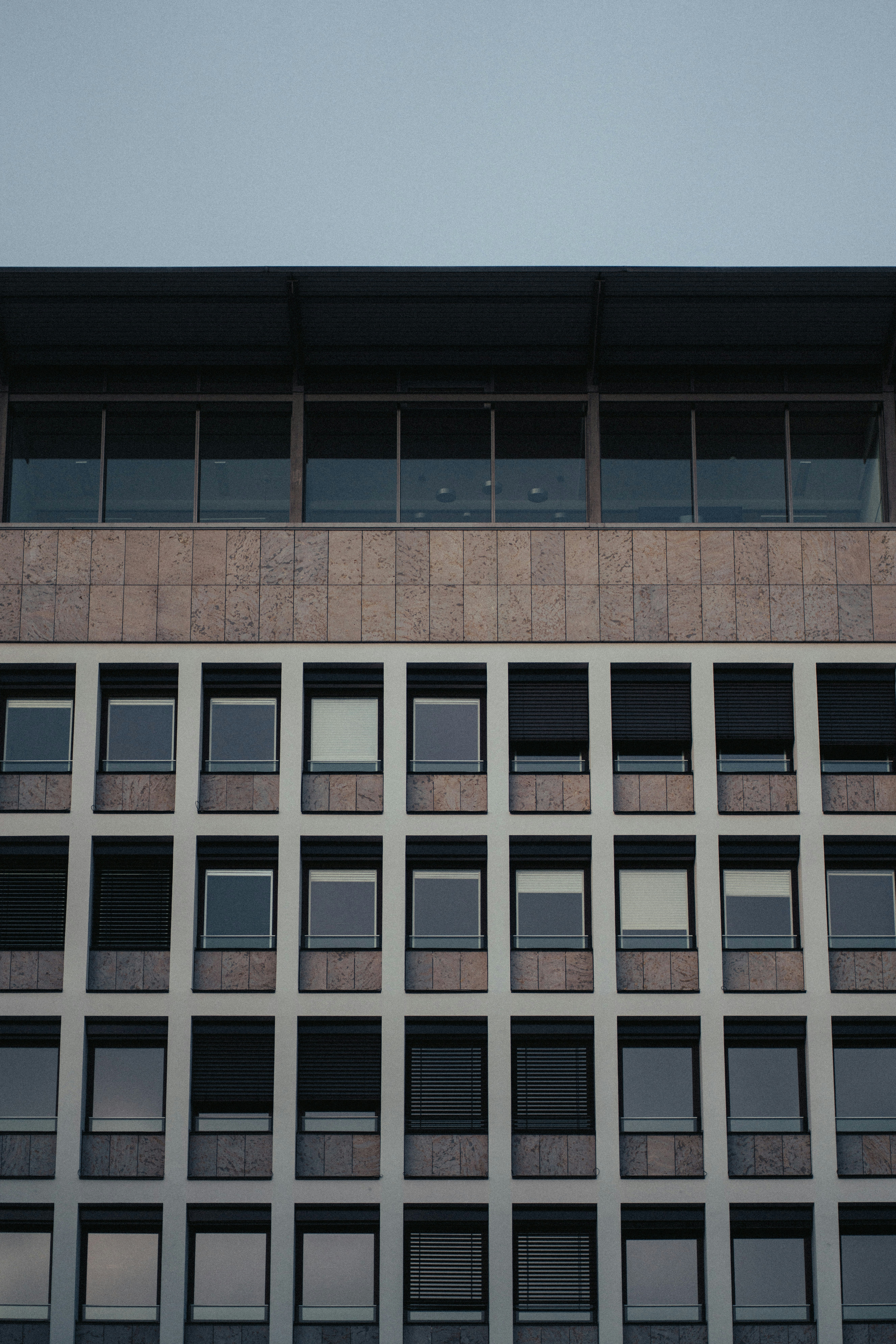 Architectural close-up of a contemporary building showcasing a grid of windows and textured surfaces.