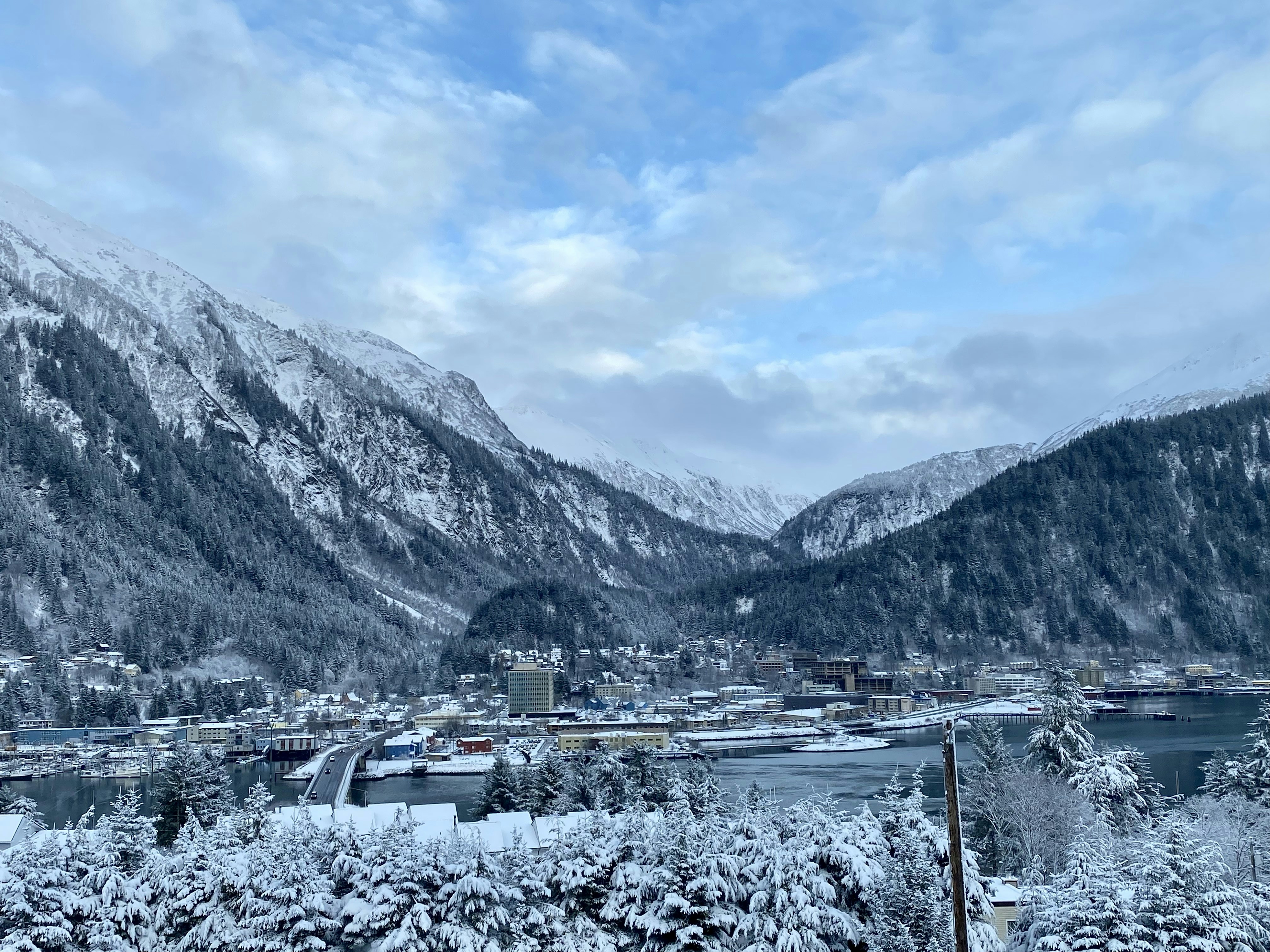 A view of a town in the mountains covered in snow photo – Free Juneau ...