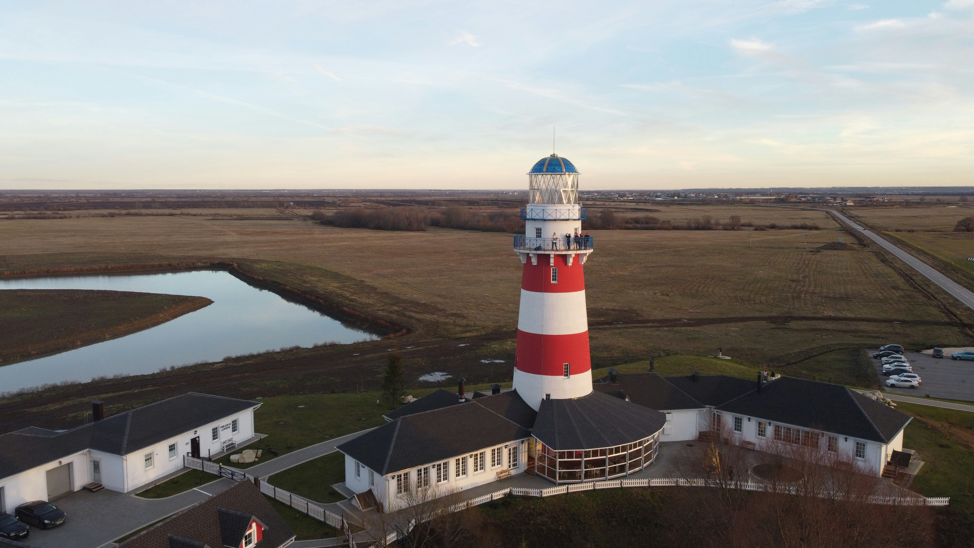 an aerial view of a lighthouse with a body of water in the background